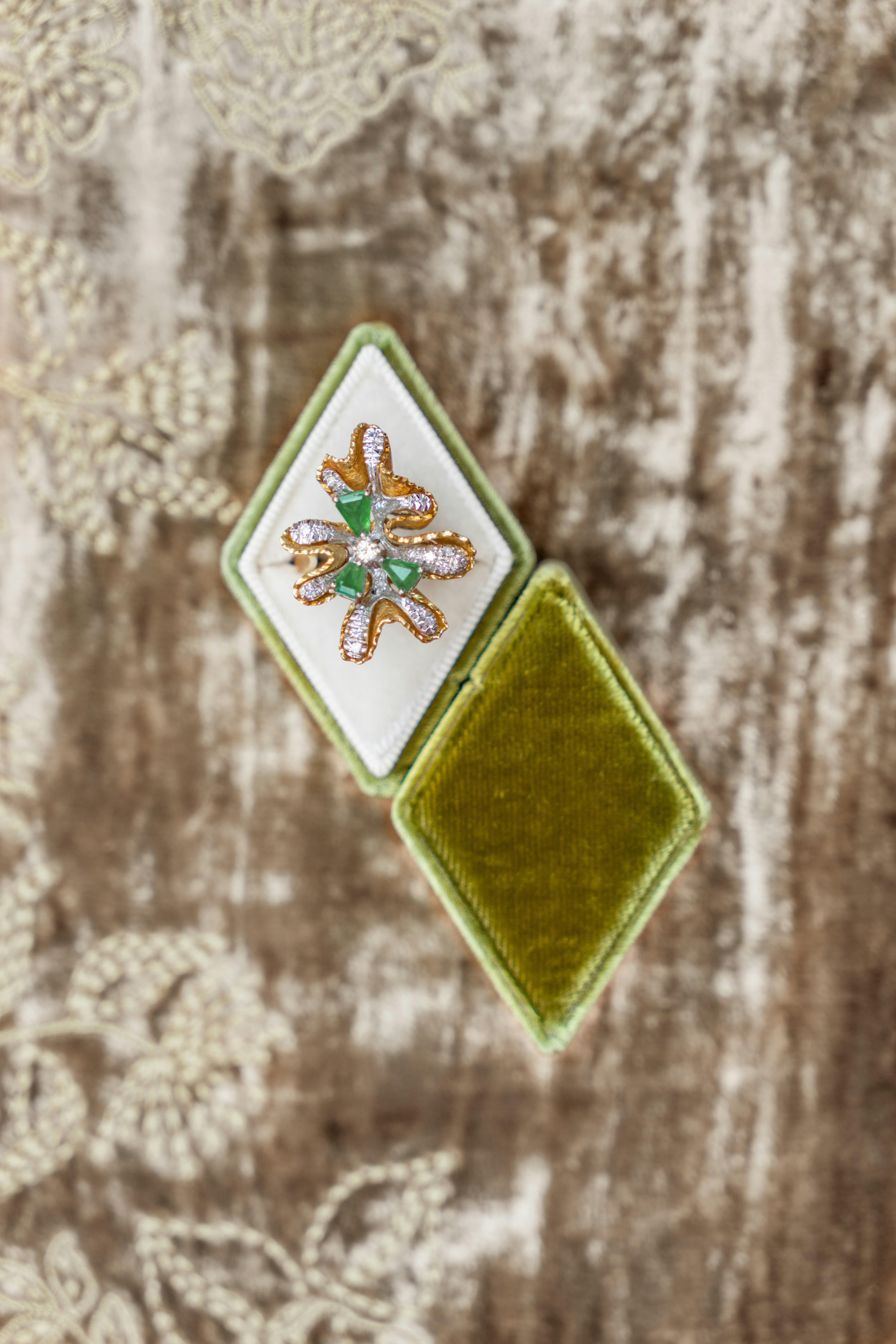 Intricate jewelry piece displayed in a luxurious velvet box, showcasing vibrant gemstones and delicate craftsmanship.