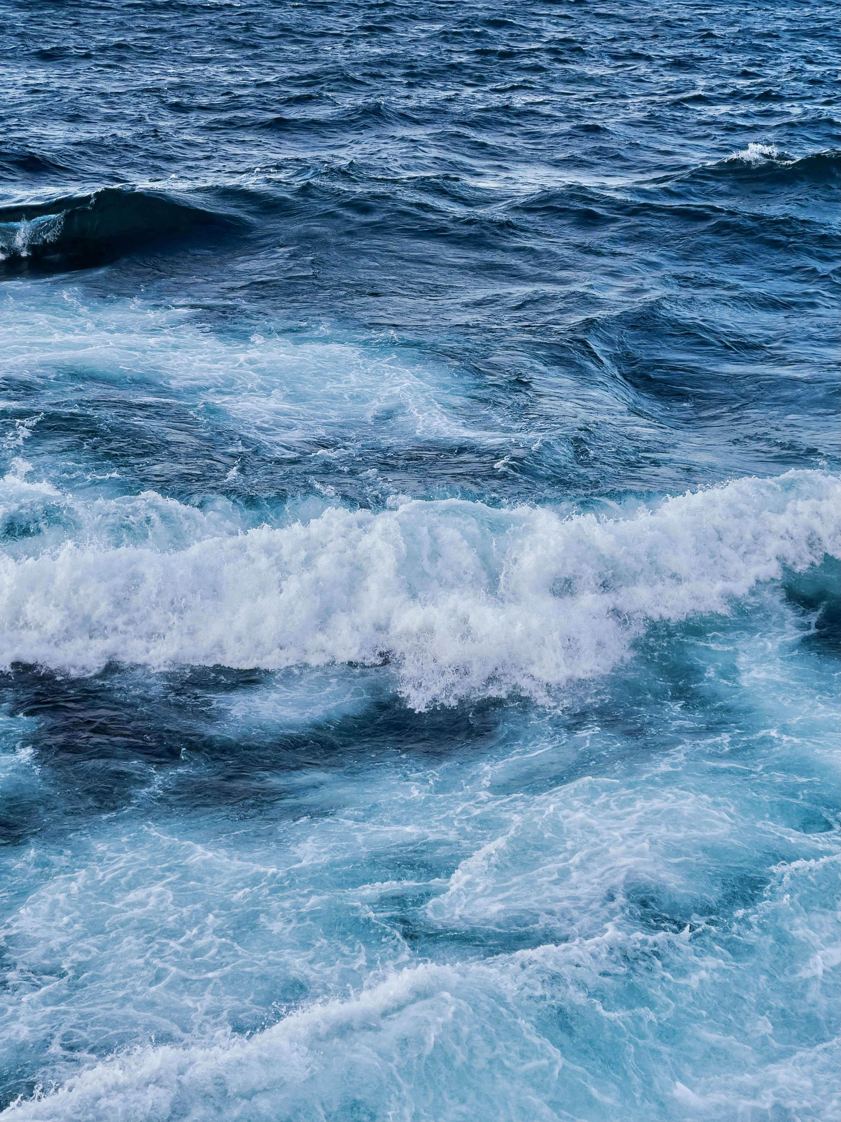 Waves breaking near the beach | white ship on sea waves during daytime