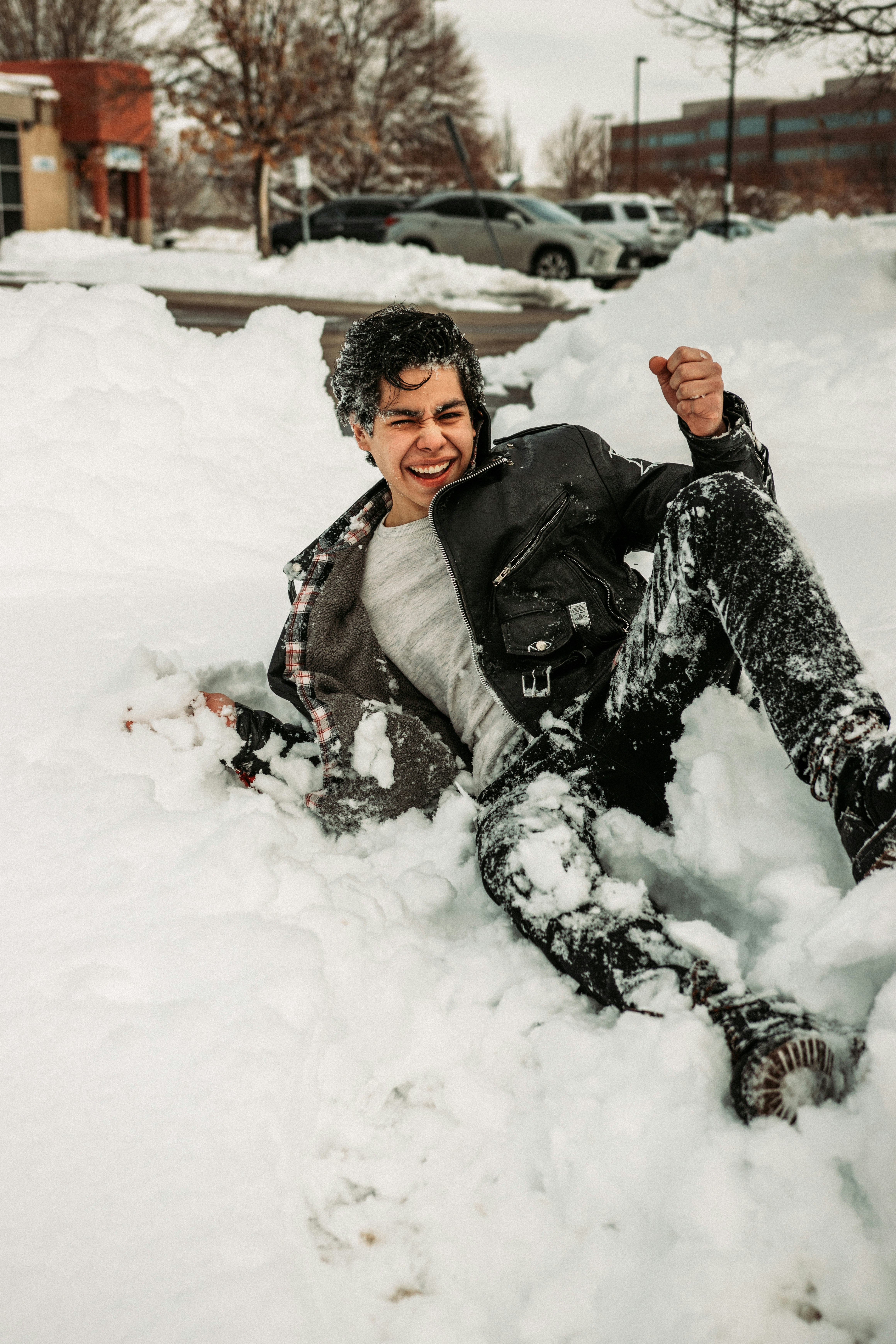 Man in black jacket sitting on snow covered ground during daytime photo ...