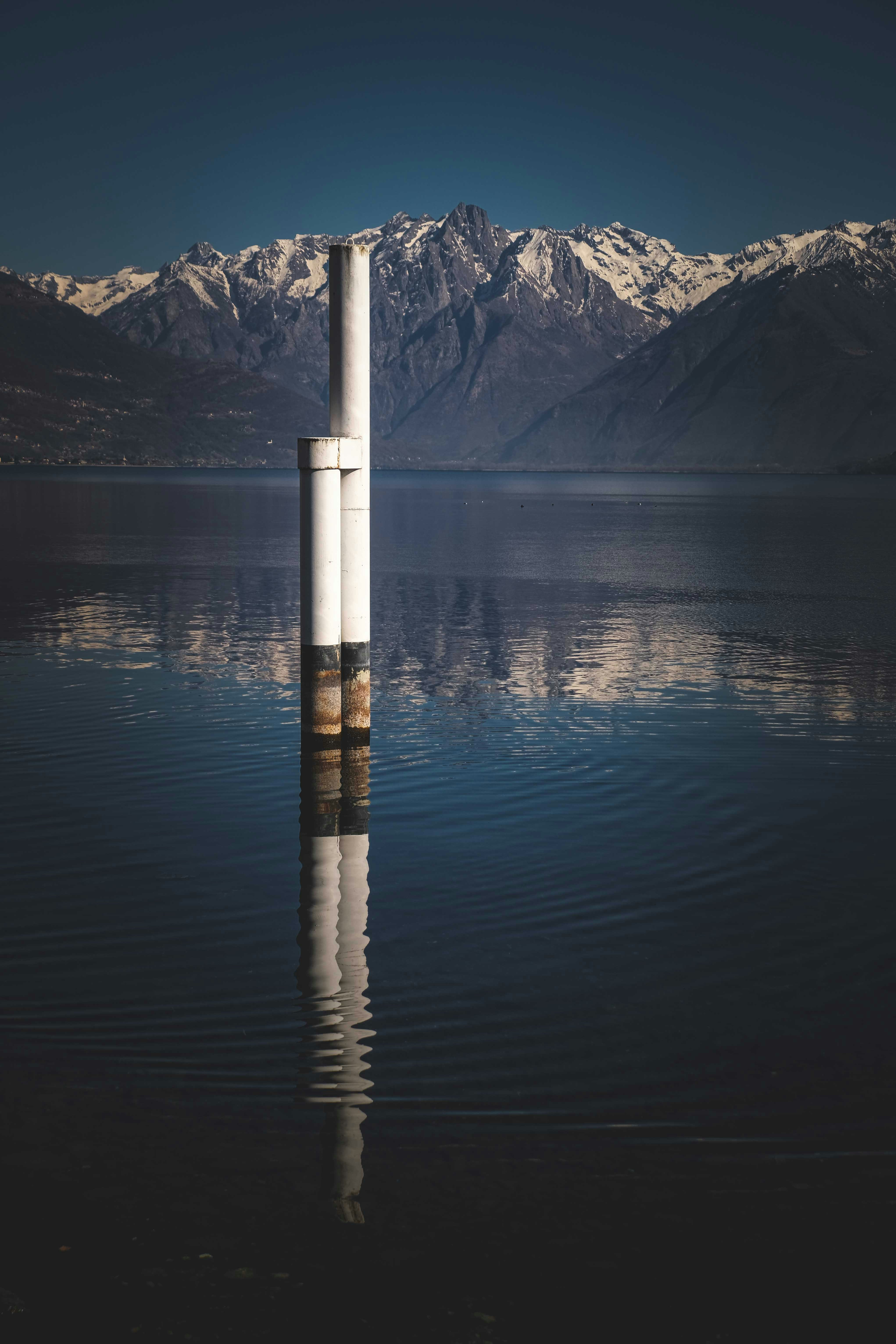 Vertical Pier in Calm Lake with Snowy Range Backdrop