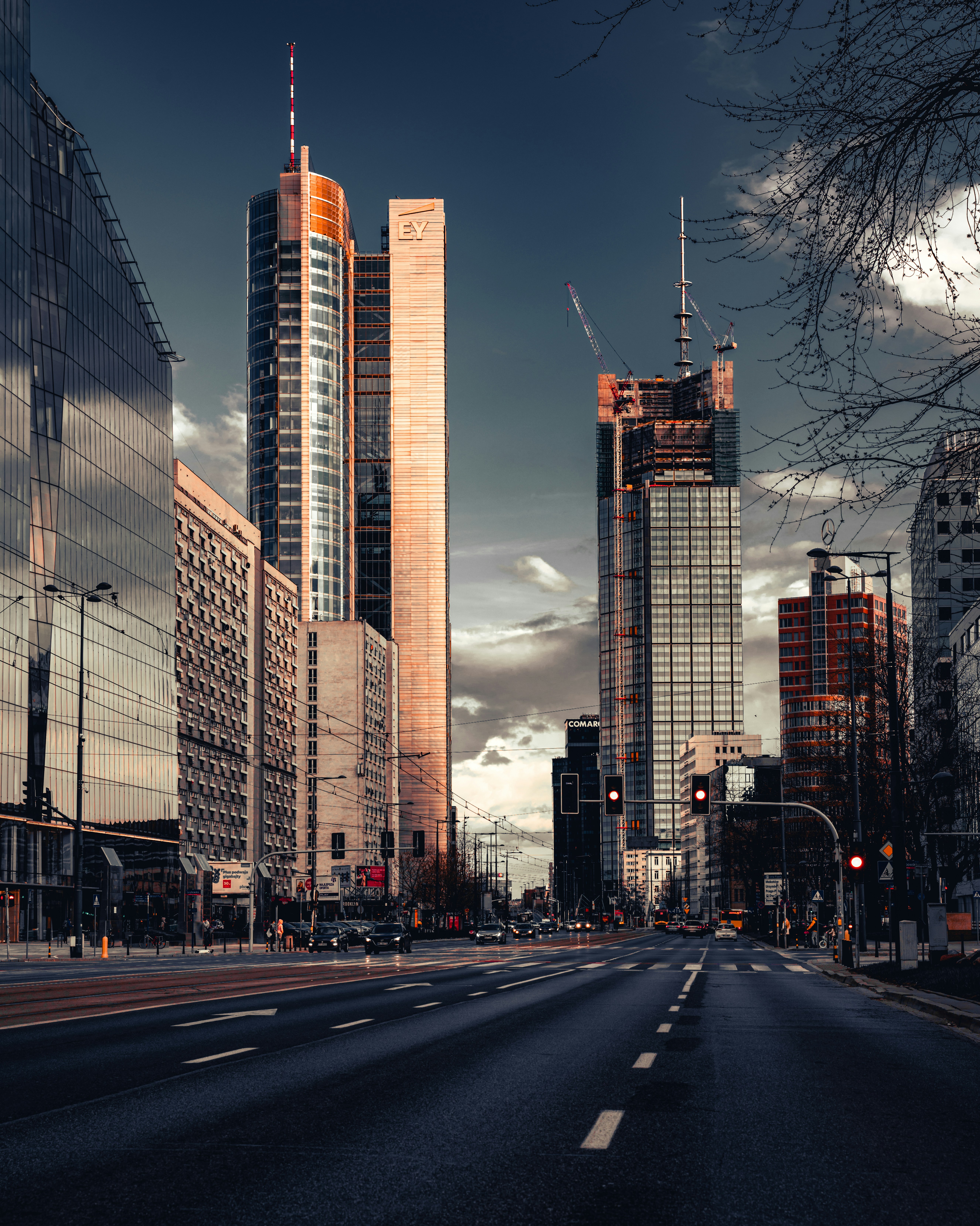 A dynamic cityscape showcasing a blend of contemporary skyscrapers and reflective glass facades under a dramatic sky.