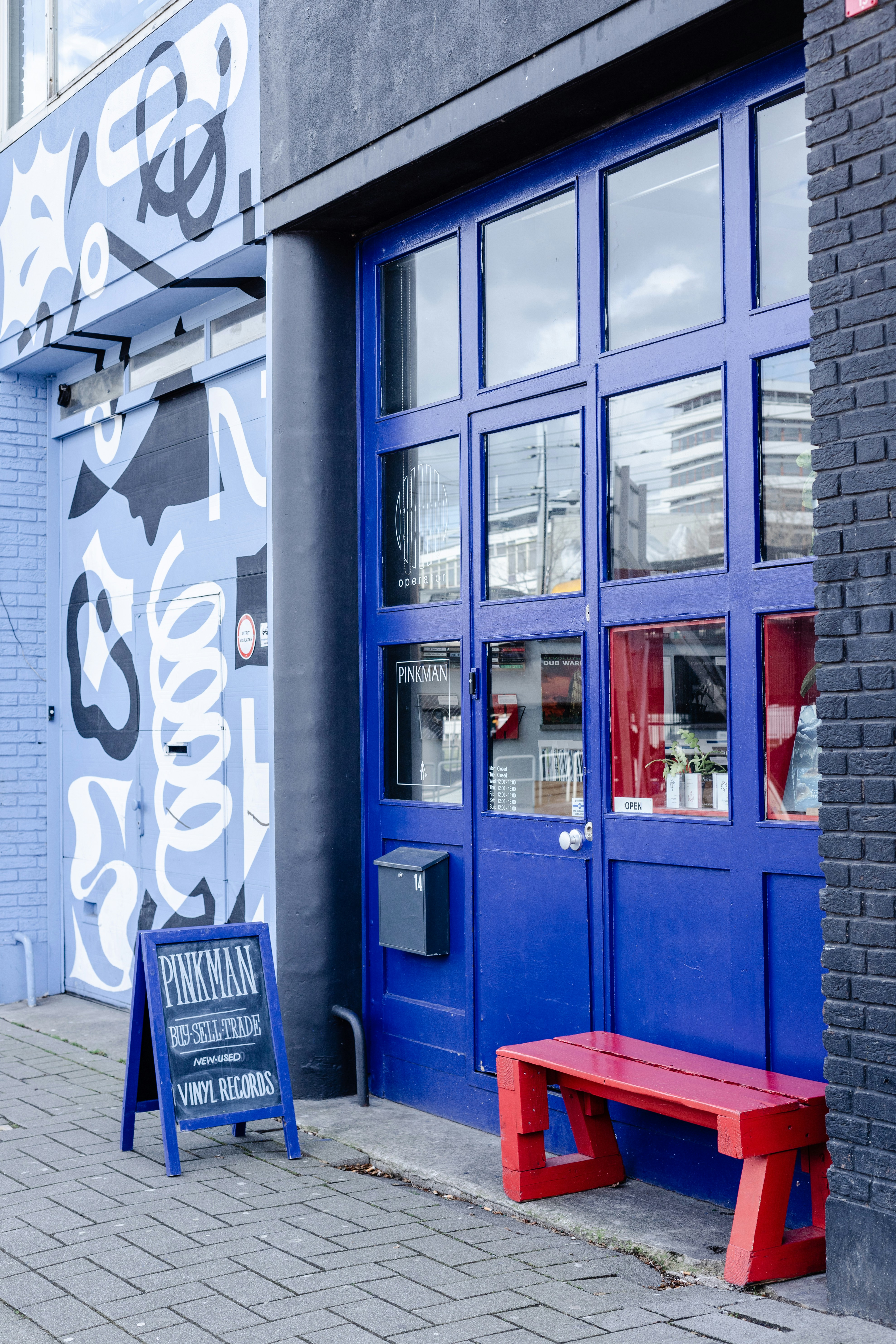 Blue Door Studio: Neon Entrance at a Graffiti-Patterned Façade