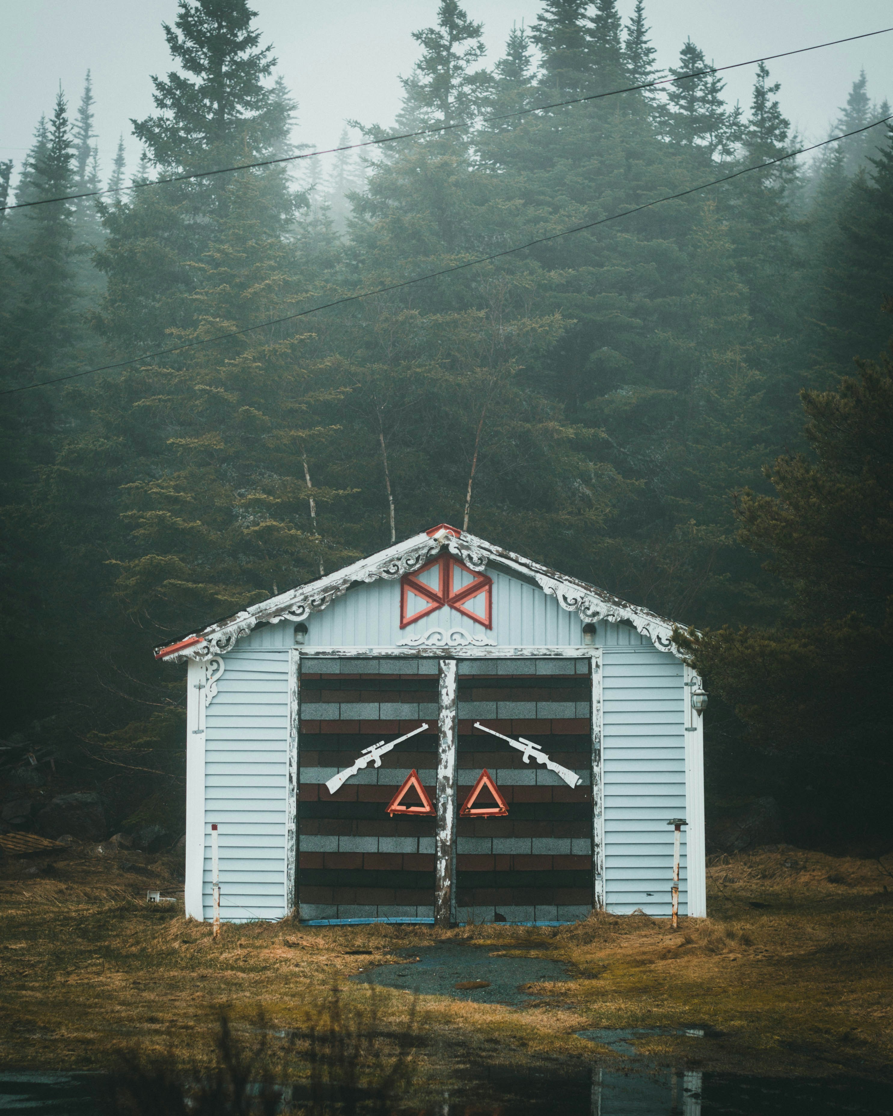 white and red wooden house near green trees during daytime