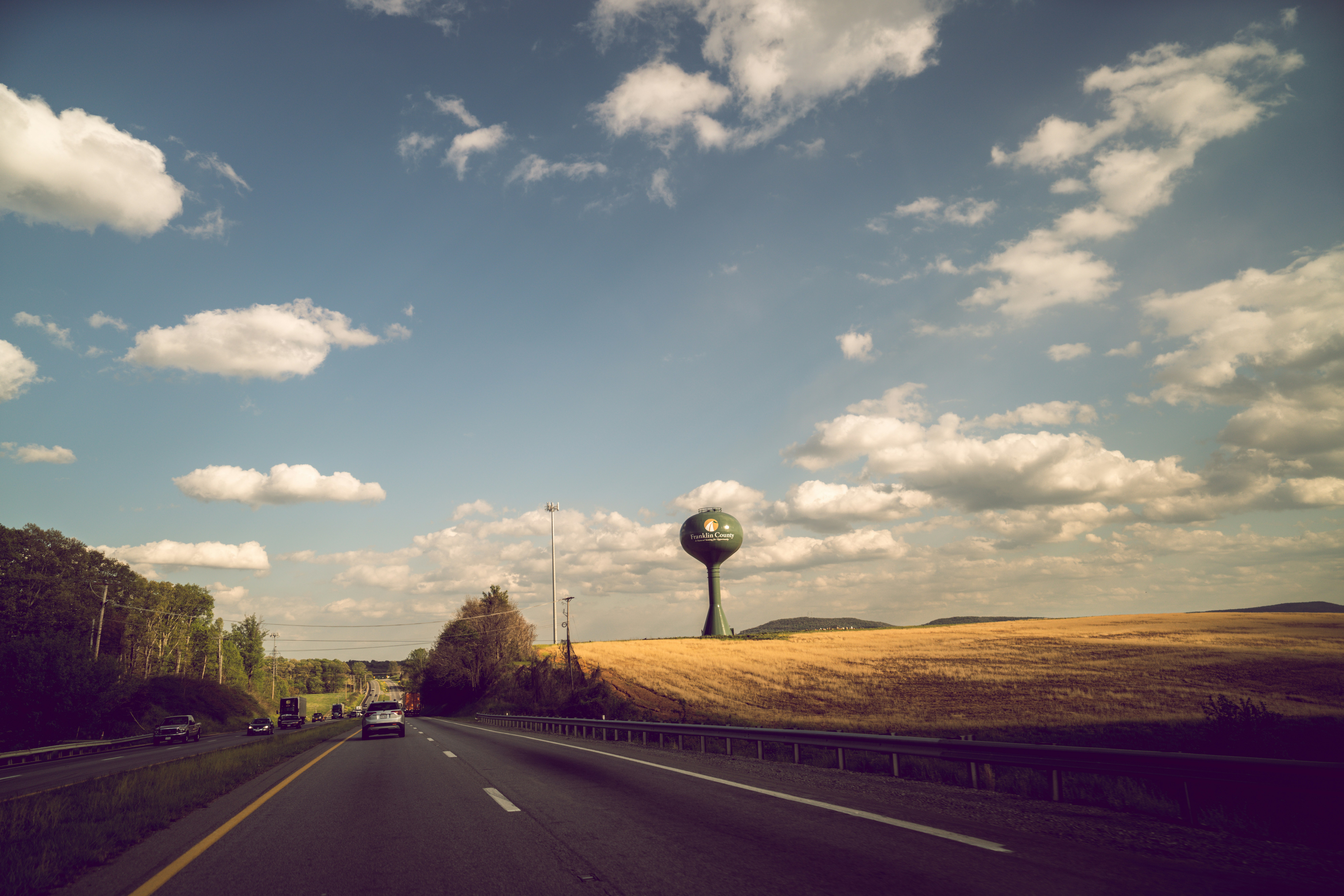 Highway to Horizon: A Water-Tower Sentinel Over Open Fields