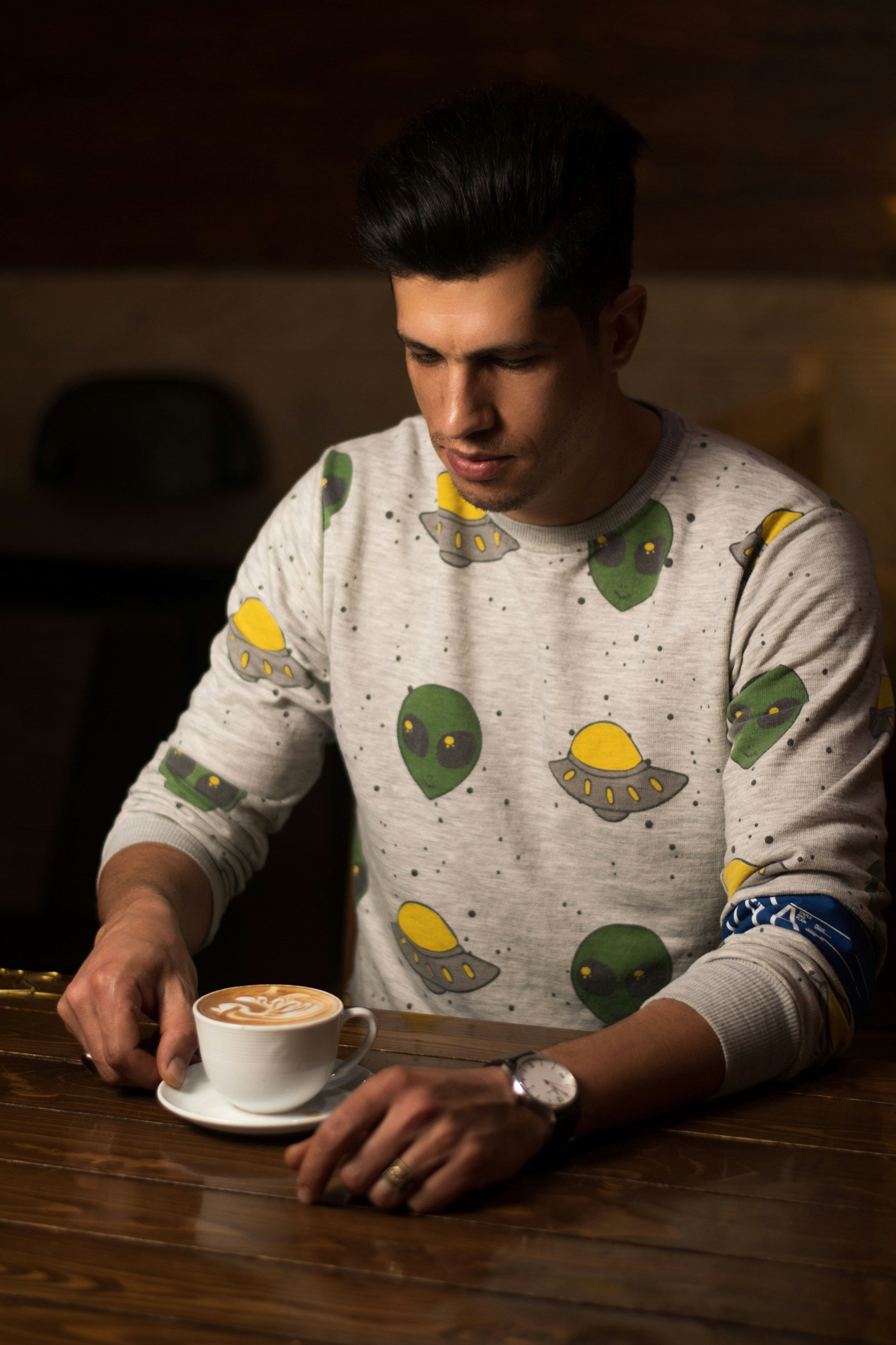 Gaze Over Steam: A Quiet Portrait Beneath Warm Café Light