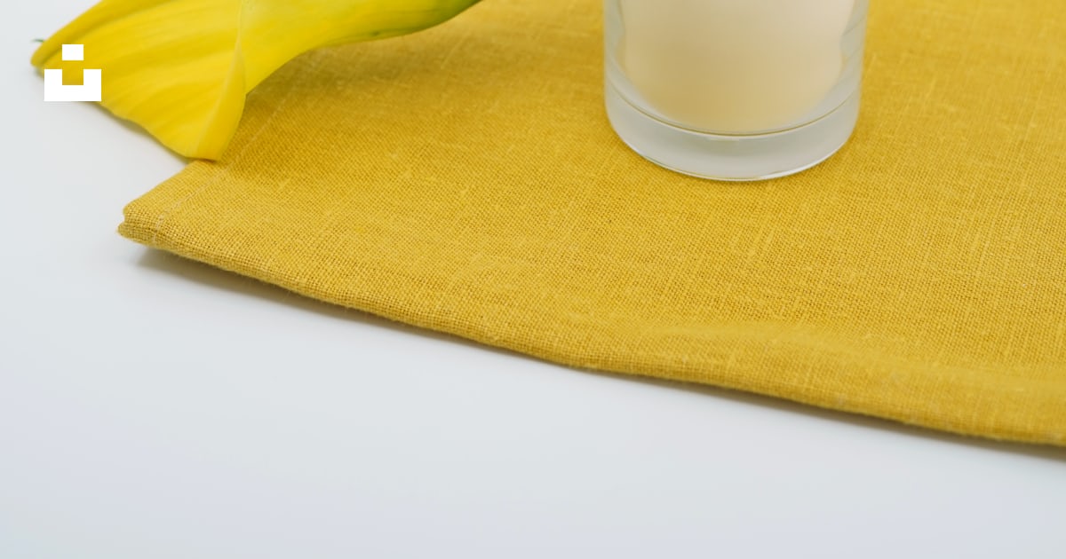 Yellow Textile Beside Clear Drinking Glass With White Liquid Photo