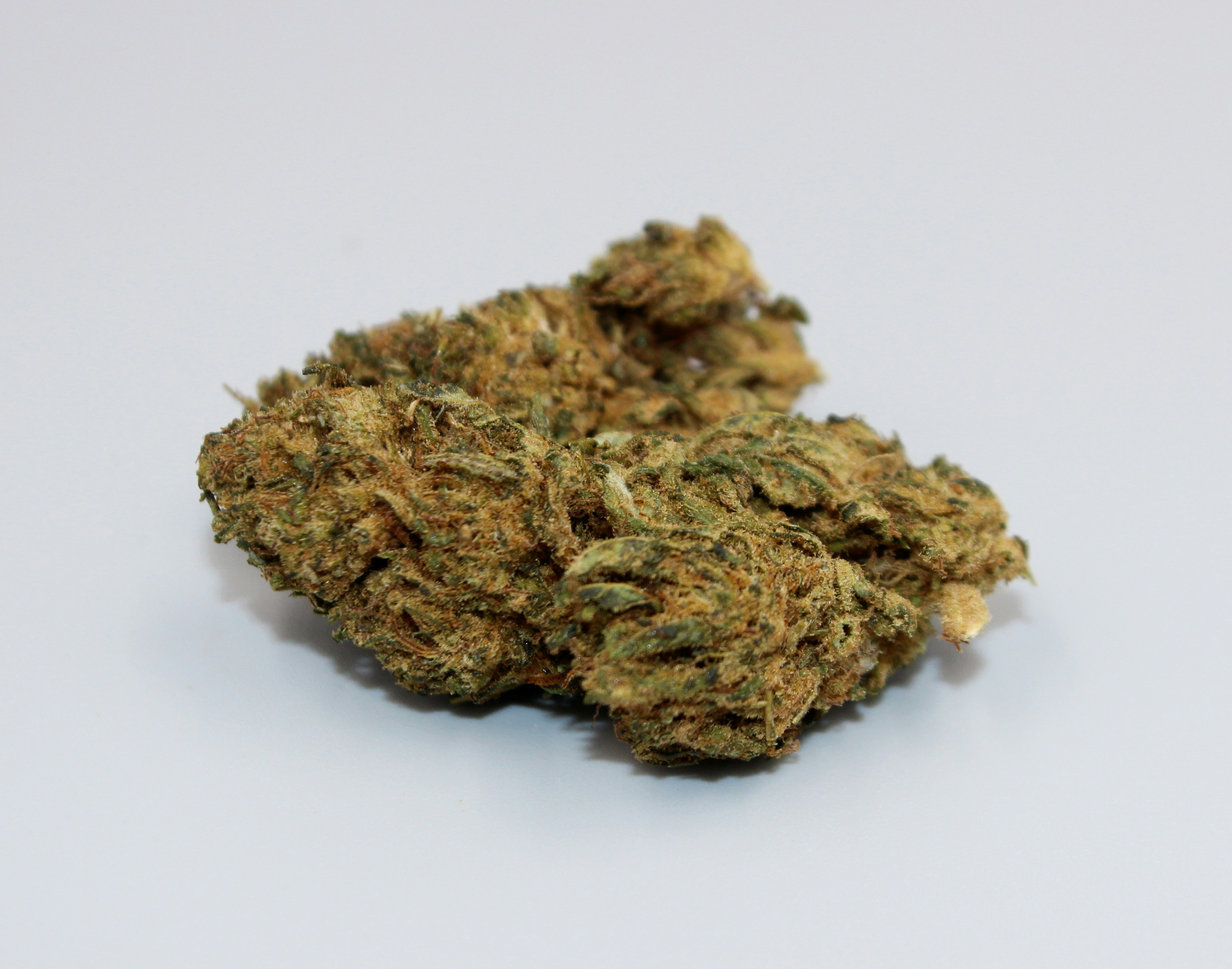 Crystallized Cannabis Buds Rest on a Pale Surface
