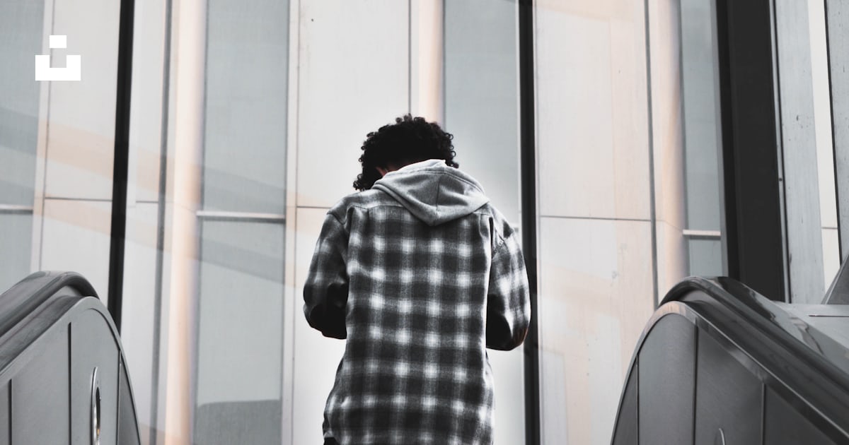 Man In Black And White Plaid Dress Shirt Standing In Front Of Glass