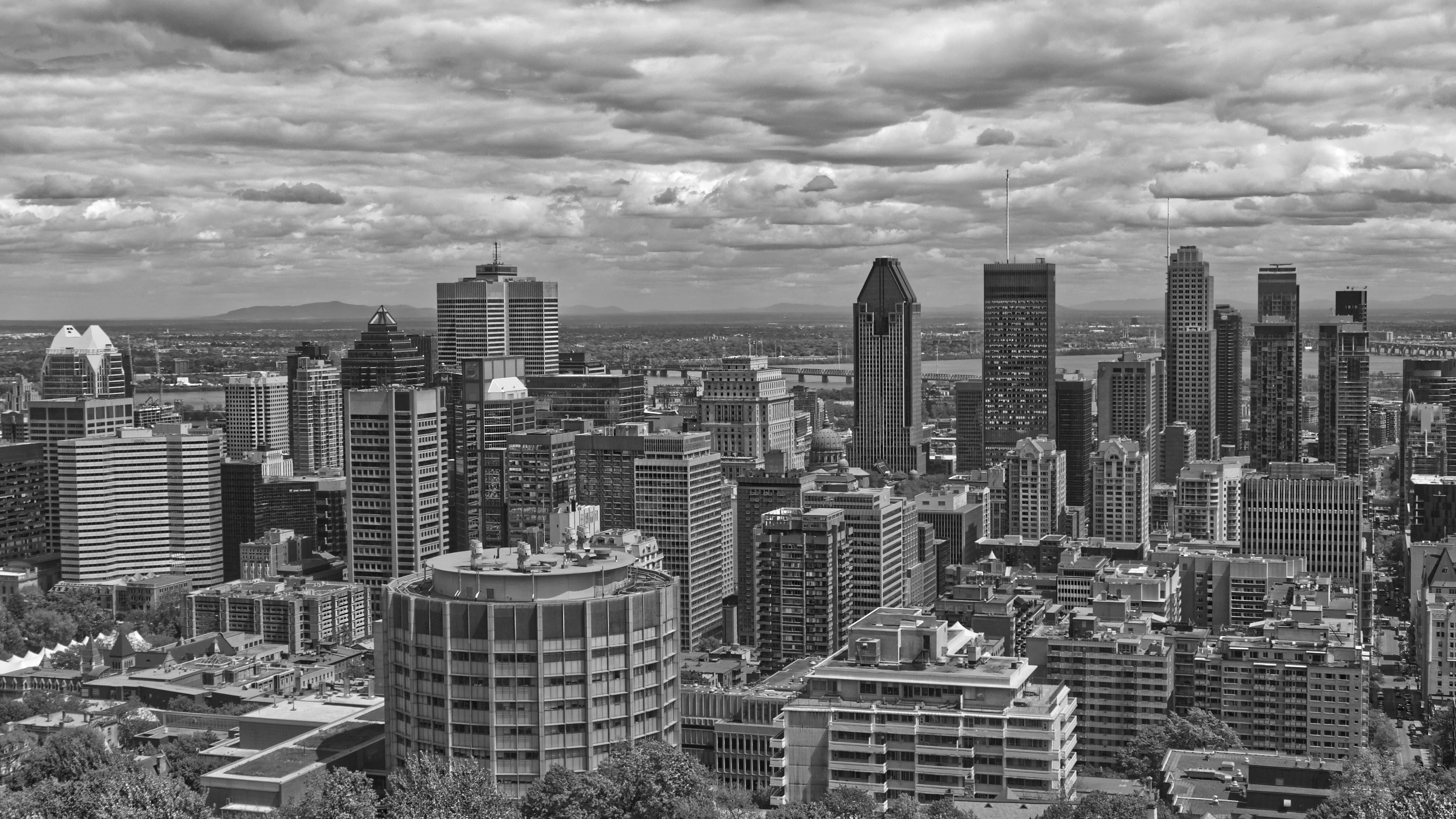 A panoramic view of a bustling city skyline, showcasing a blend of modern architecture and historical buildings under a dramatic sky.