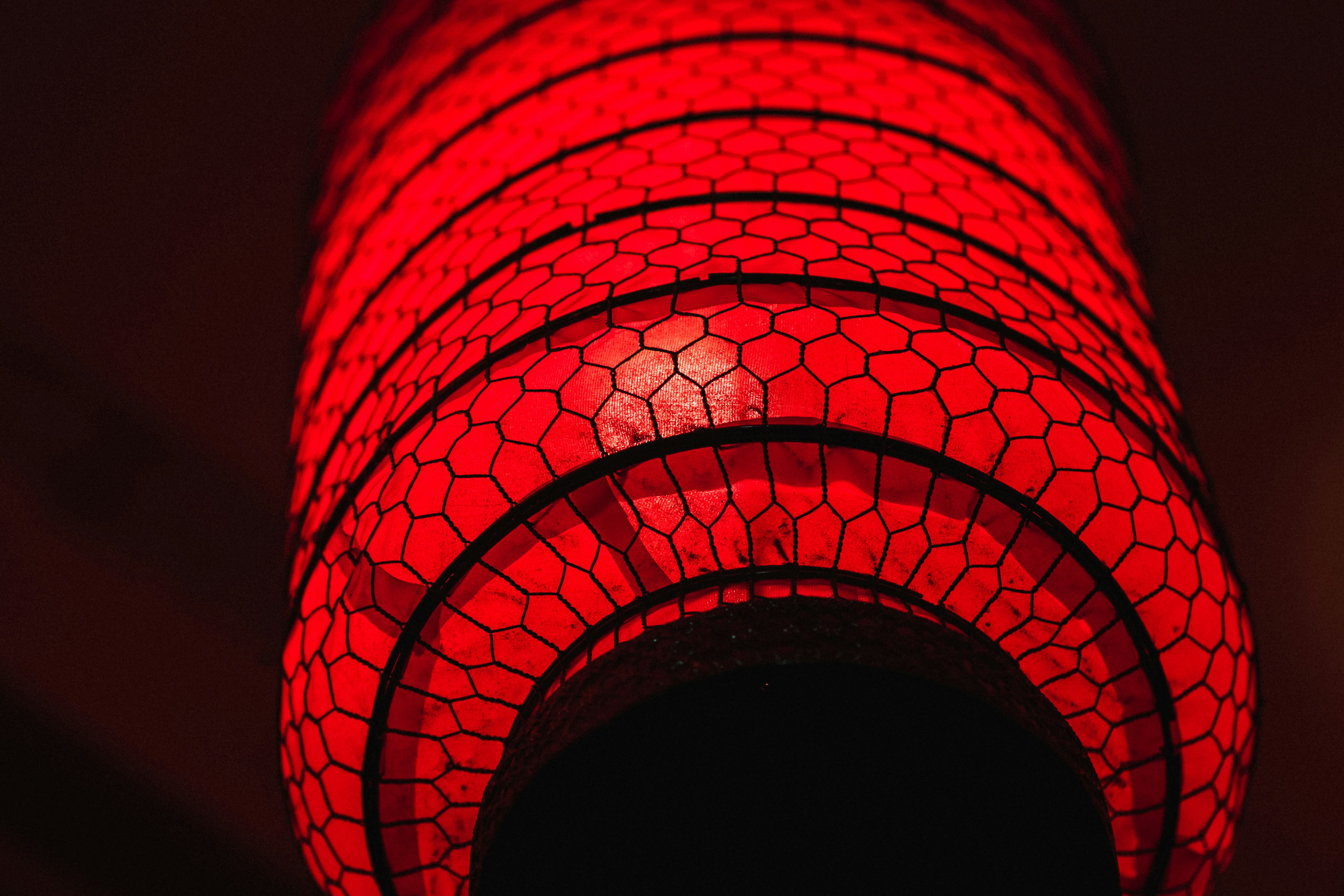 Crimson Mesh Lantern: Close-Up of Light Through Hexagonal Skin