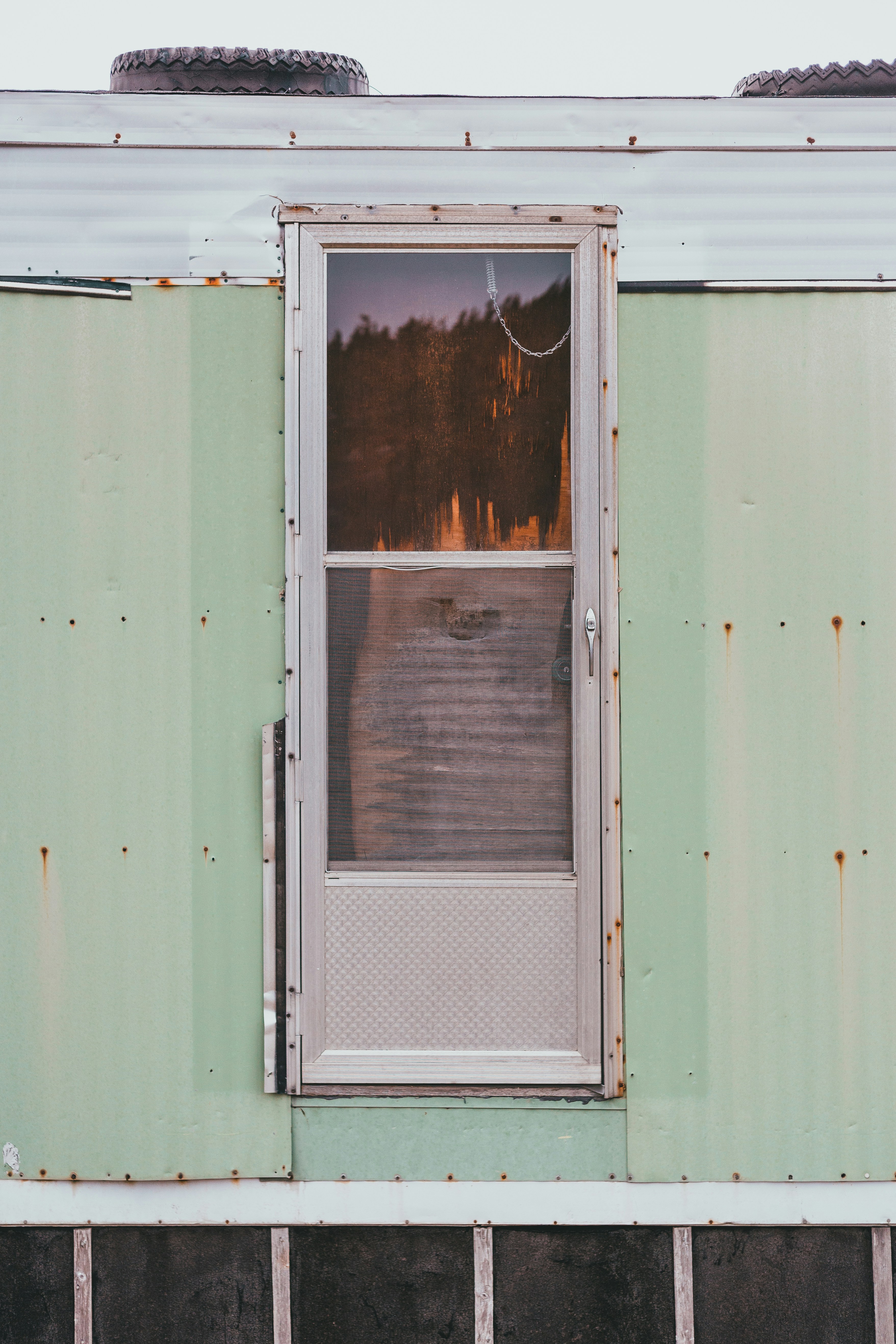 Centered Windowed Door on a Weathered Mint Trailer