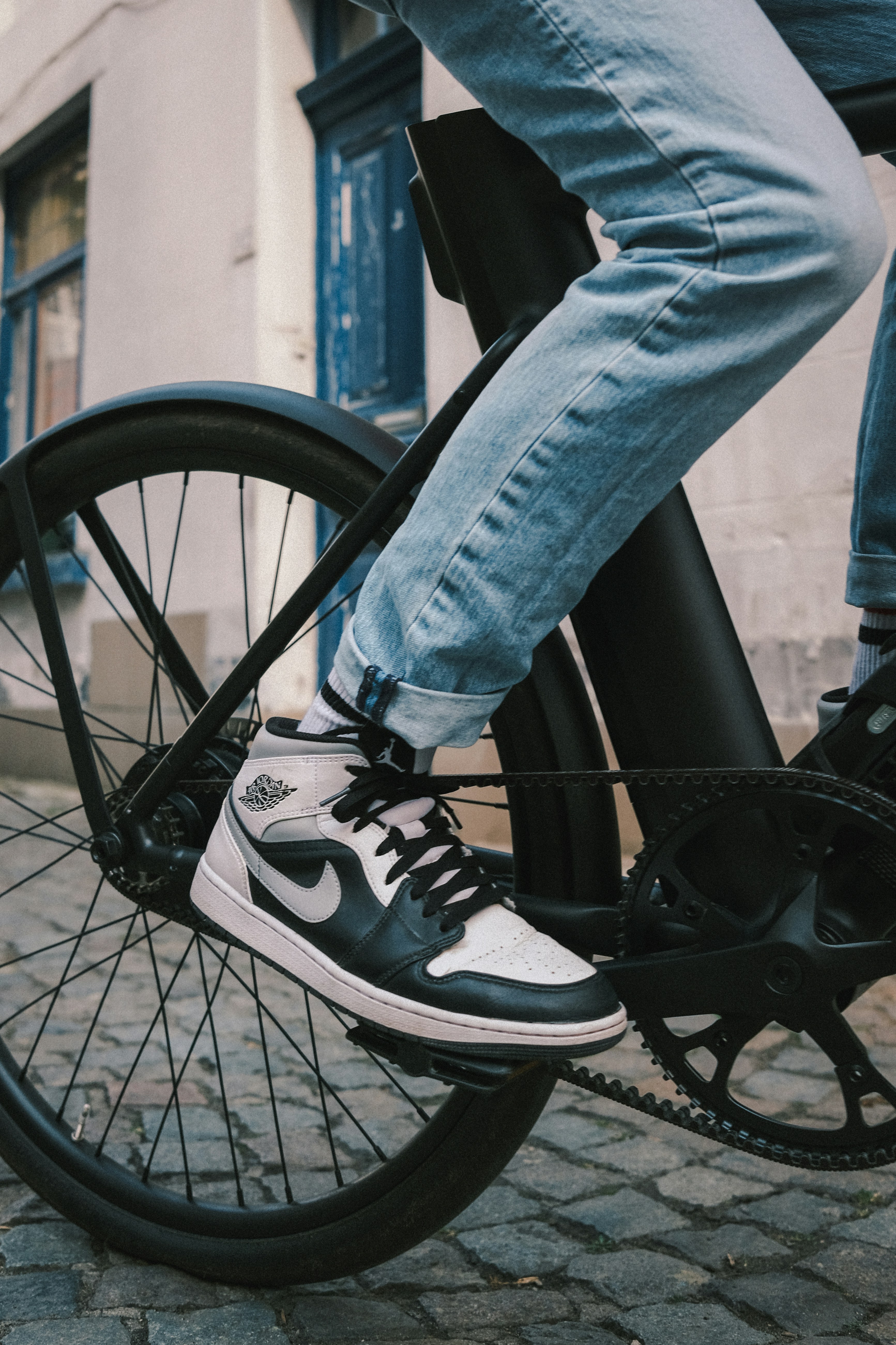 Guy riding an electric bike from Cowboy in the city wearing Nike Air Jordan 1's.