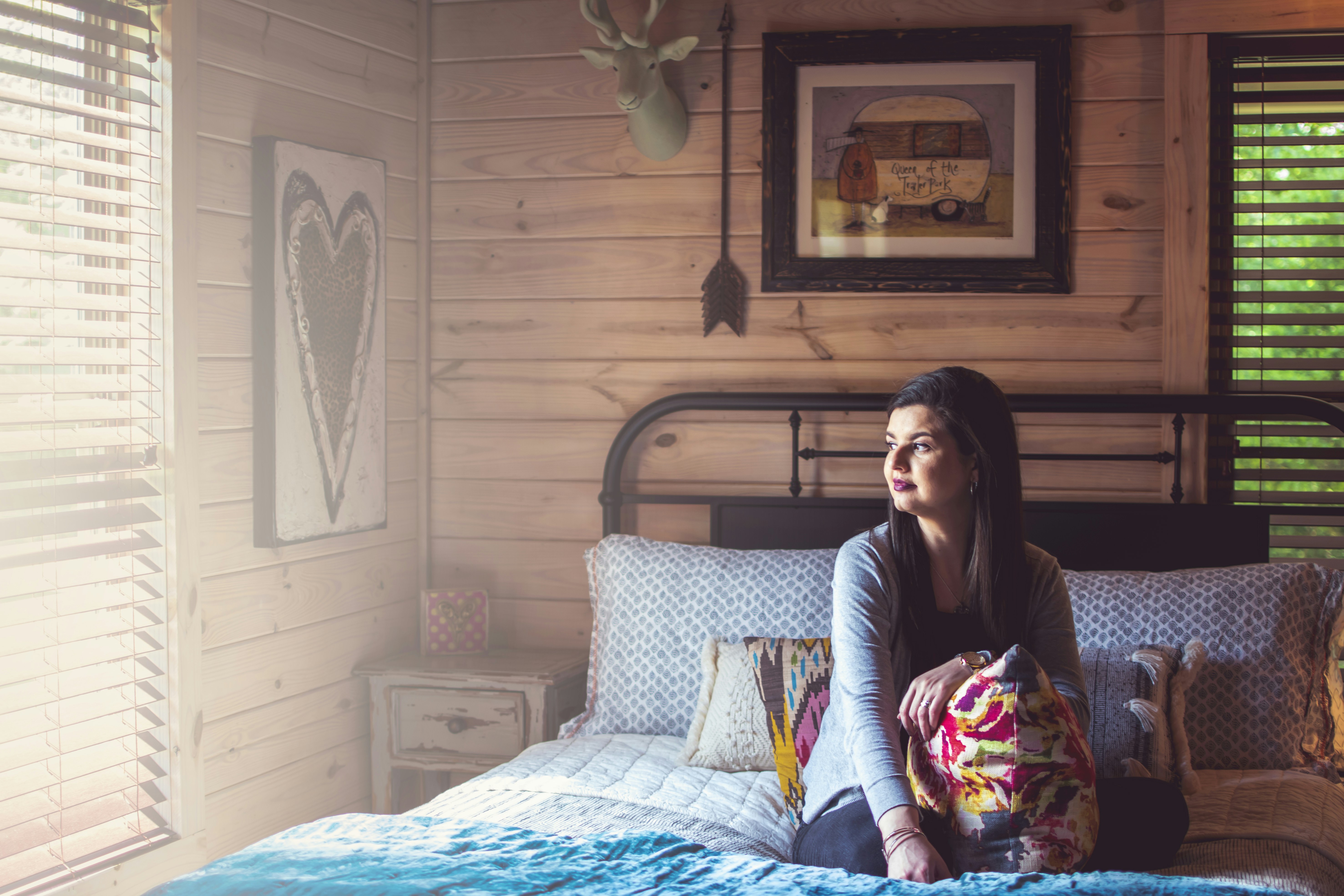 woman in purple shirt sitting on bed