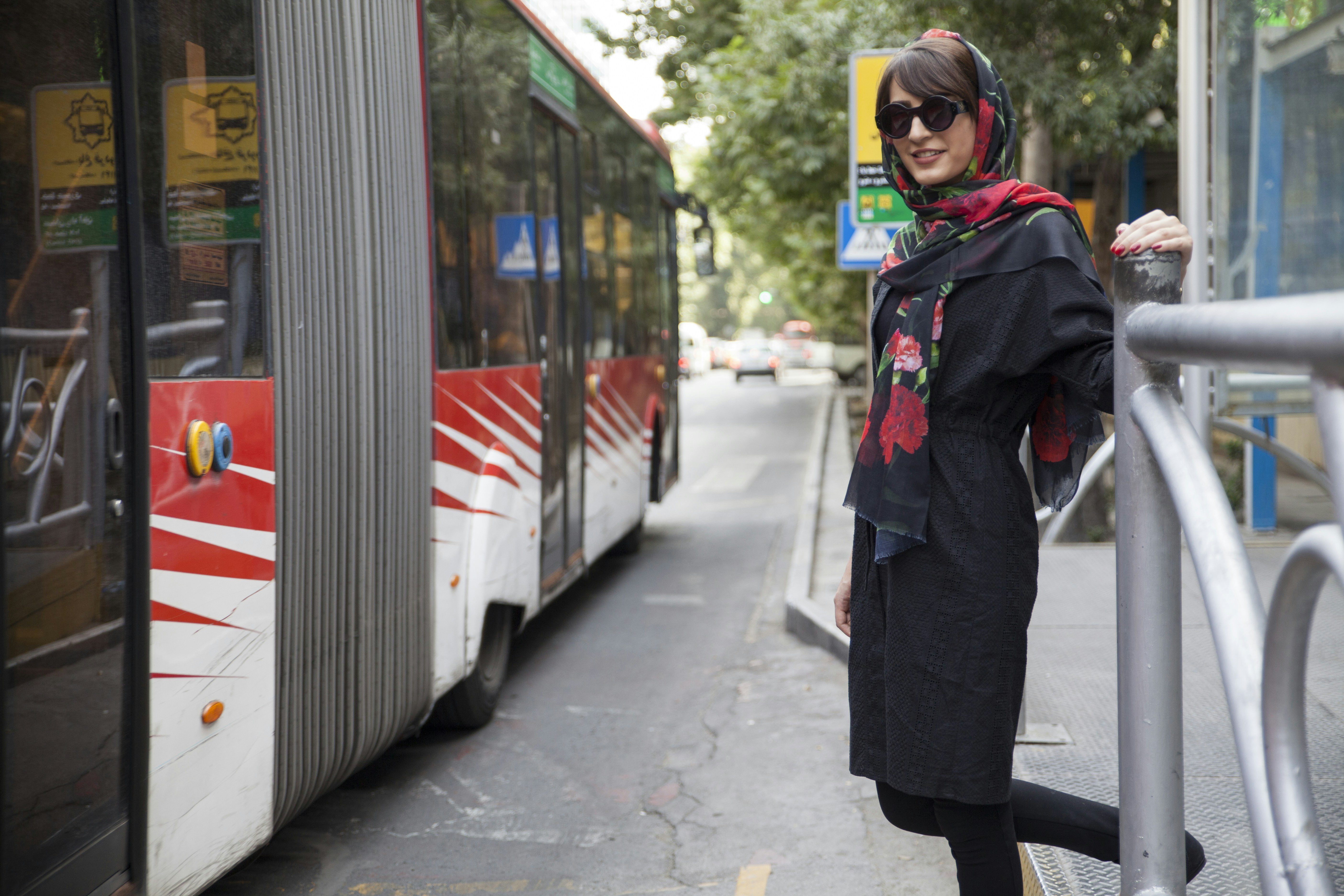 Urban Street Portrait: A Woman in a Floral Scarf at the Bus Stop