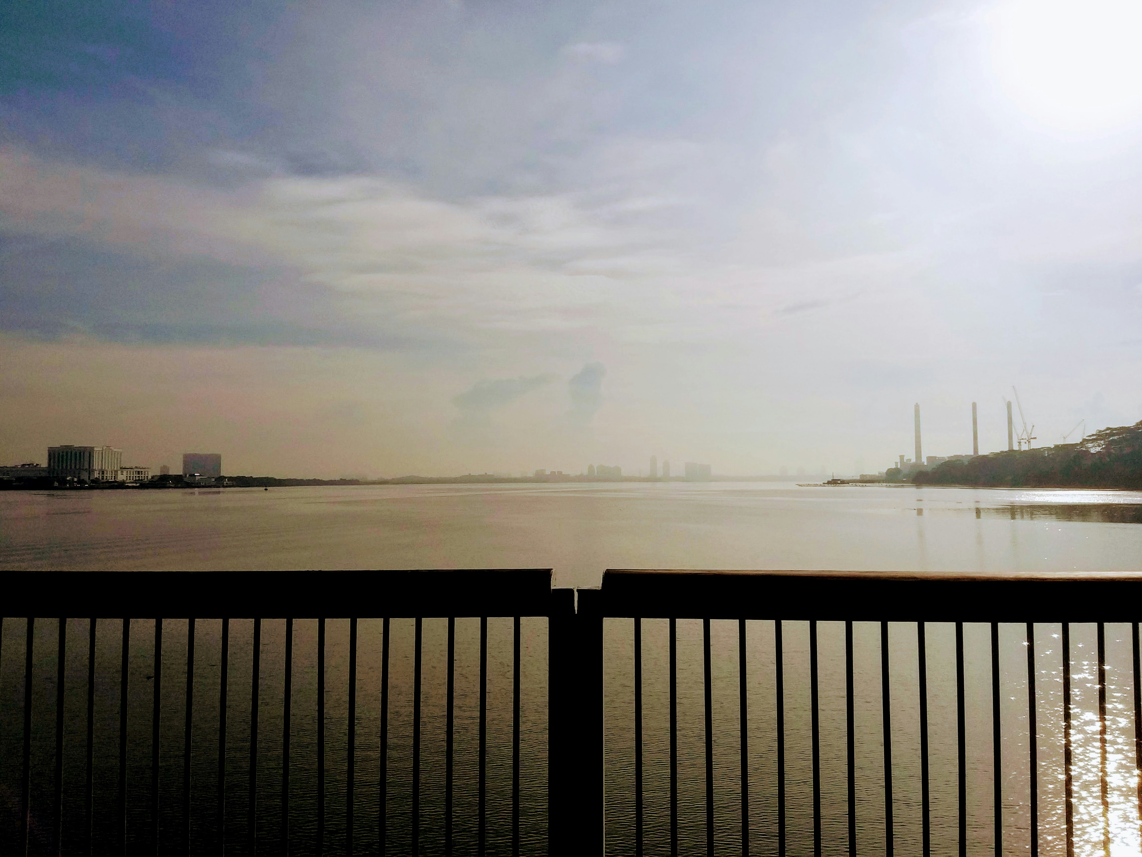 black wooden fence near body of water during daytime