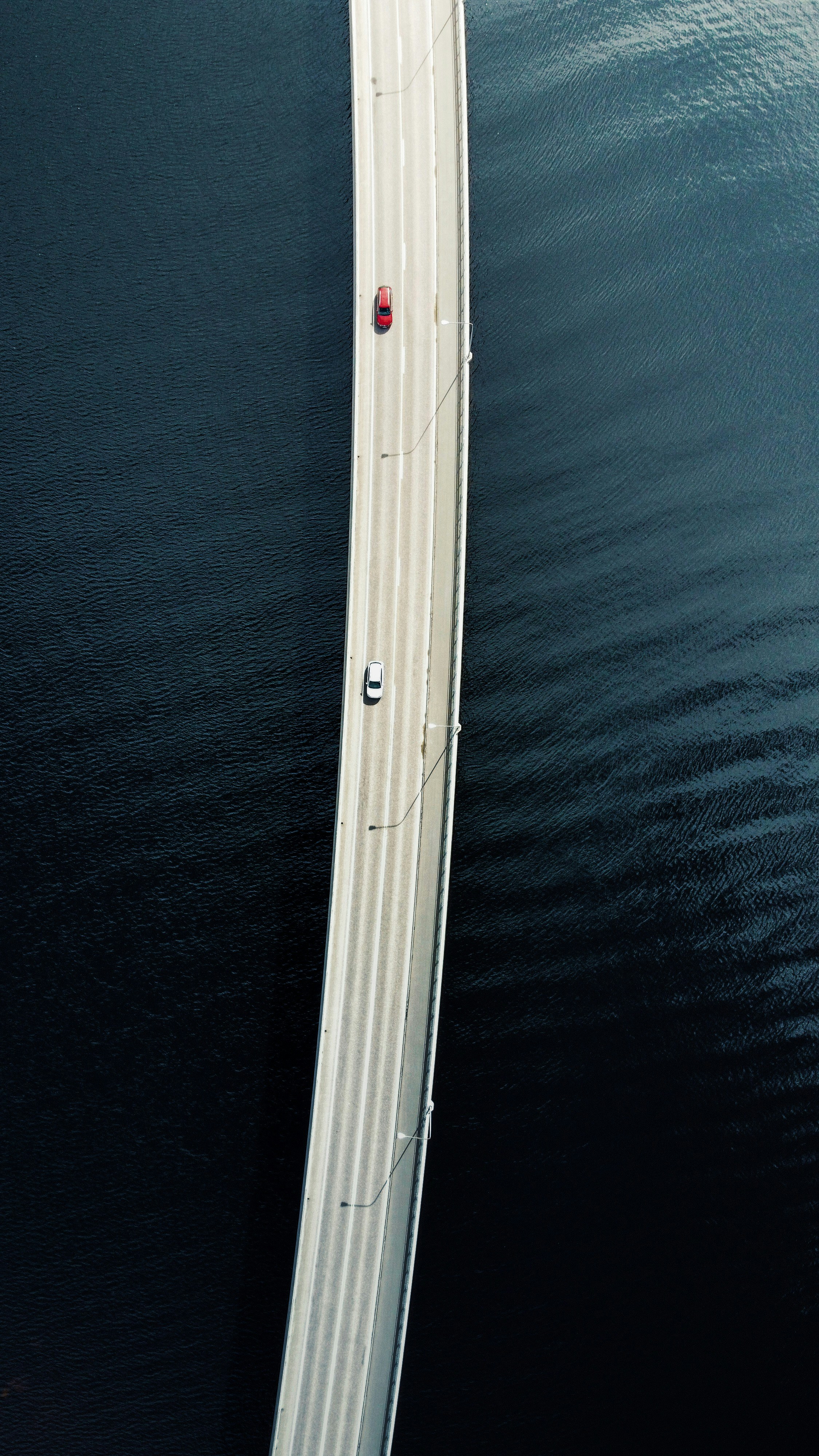 Aerial view of a bridge over a lake | white wooden stick on black textile