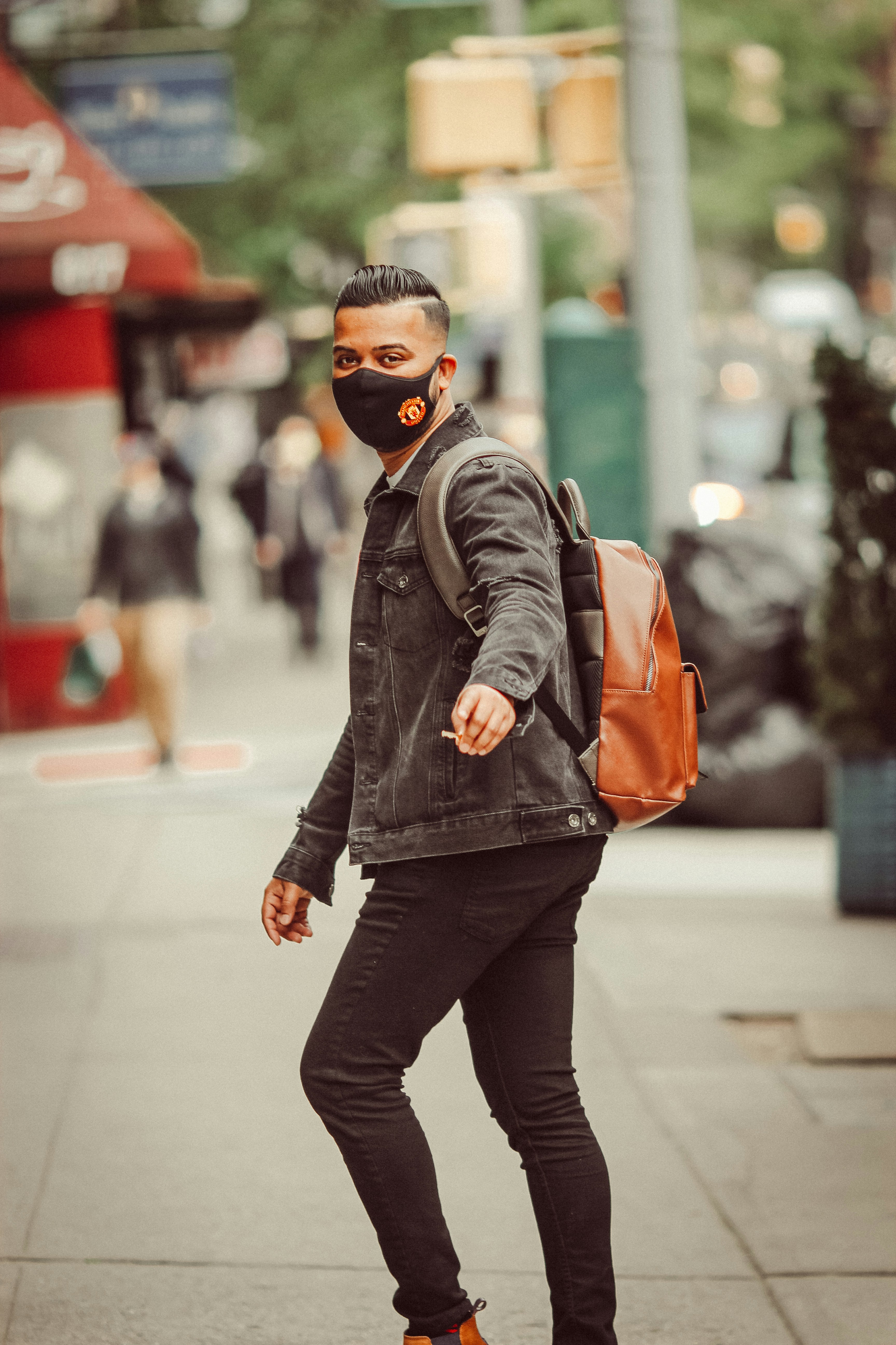 boy in black leather jacket and black pants walking on street during daytime