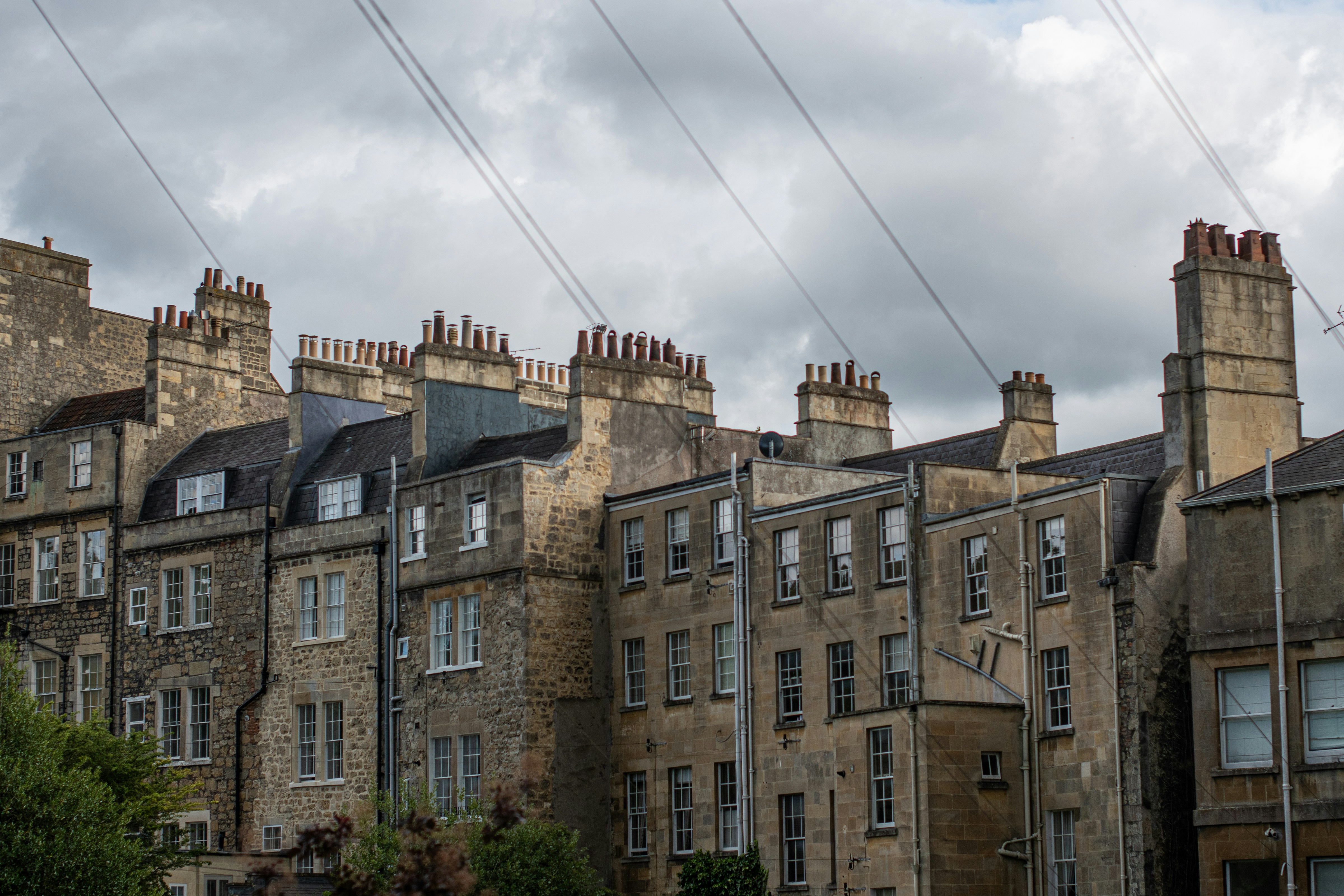yellow sandstone buildings under grey overcast sky | brown concrete building under cloudy sky during daytime