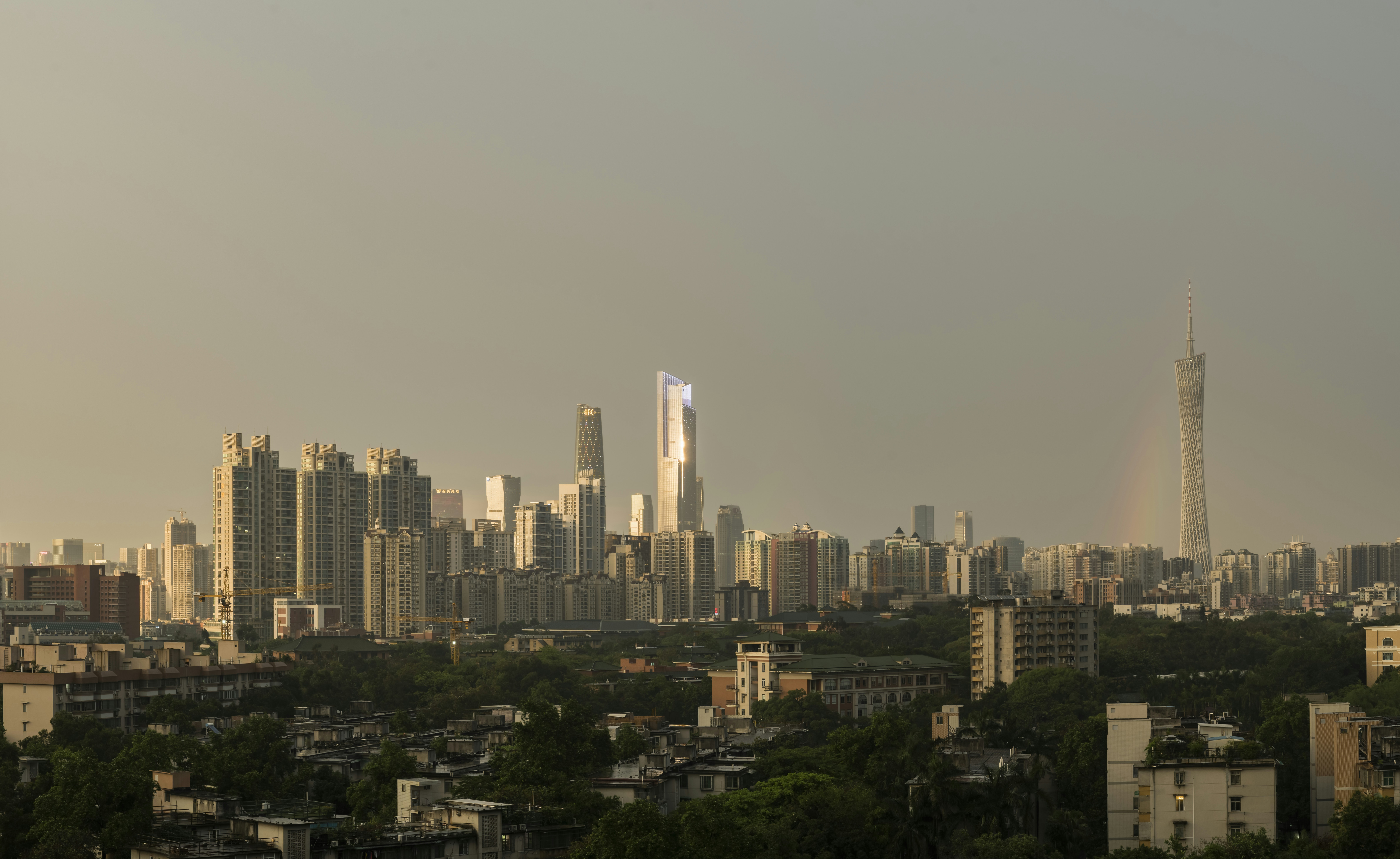 City skyline showcasing a blend of contemporary skyscrapers and traditional architecture under a hazy sky.
