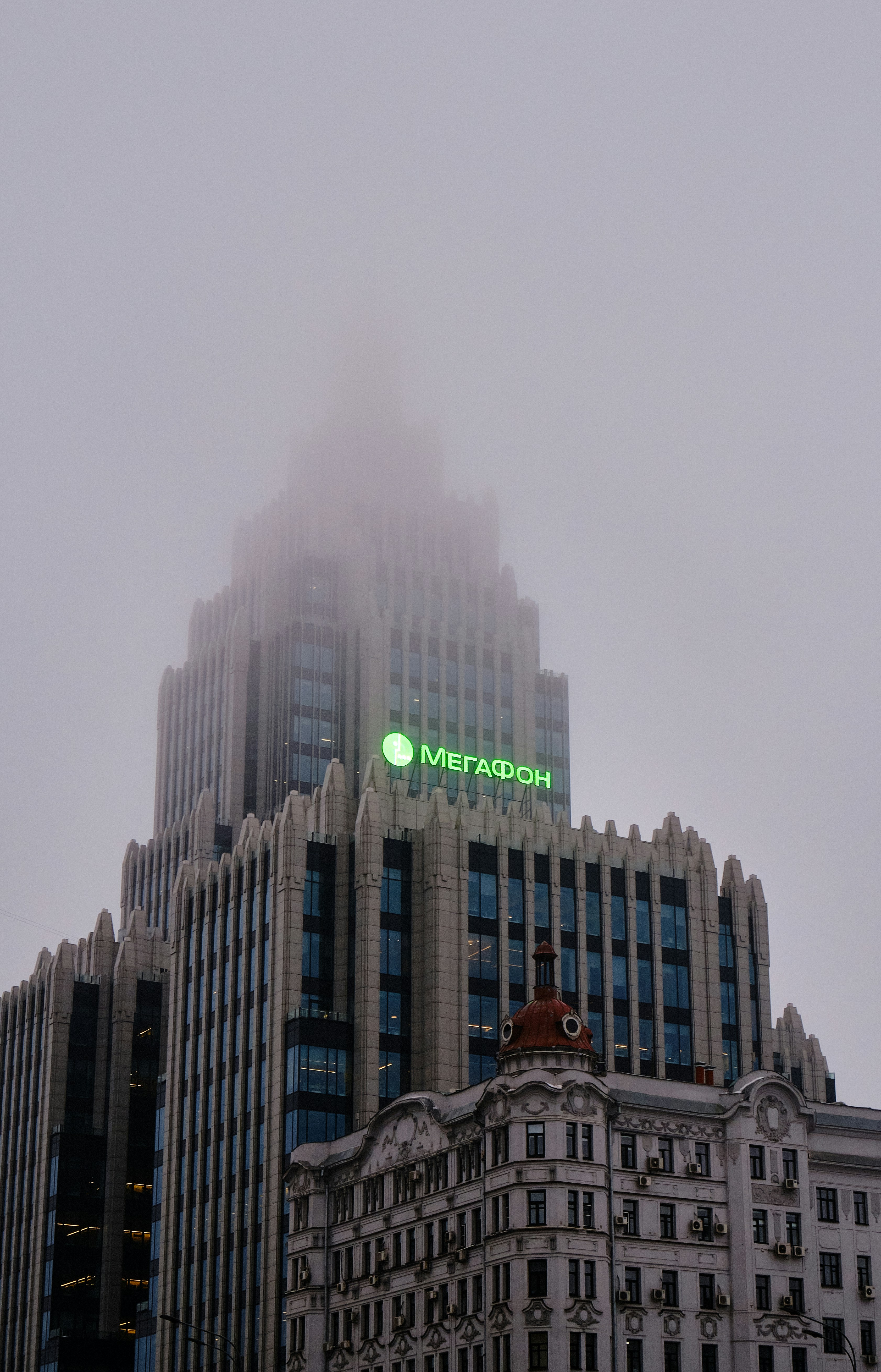 Megafon Neon Sign Pierces the Fog over a Gothic-Modern Skyline
