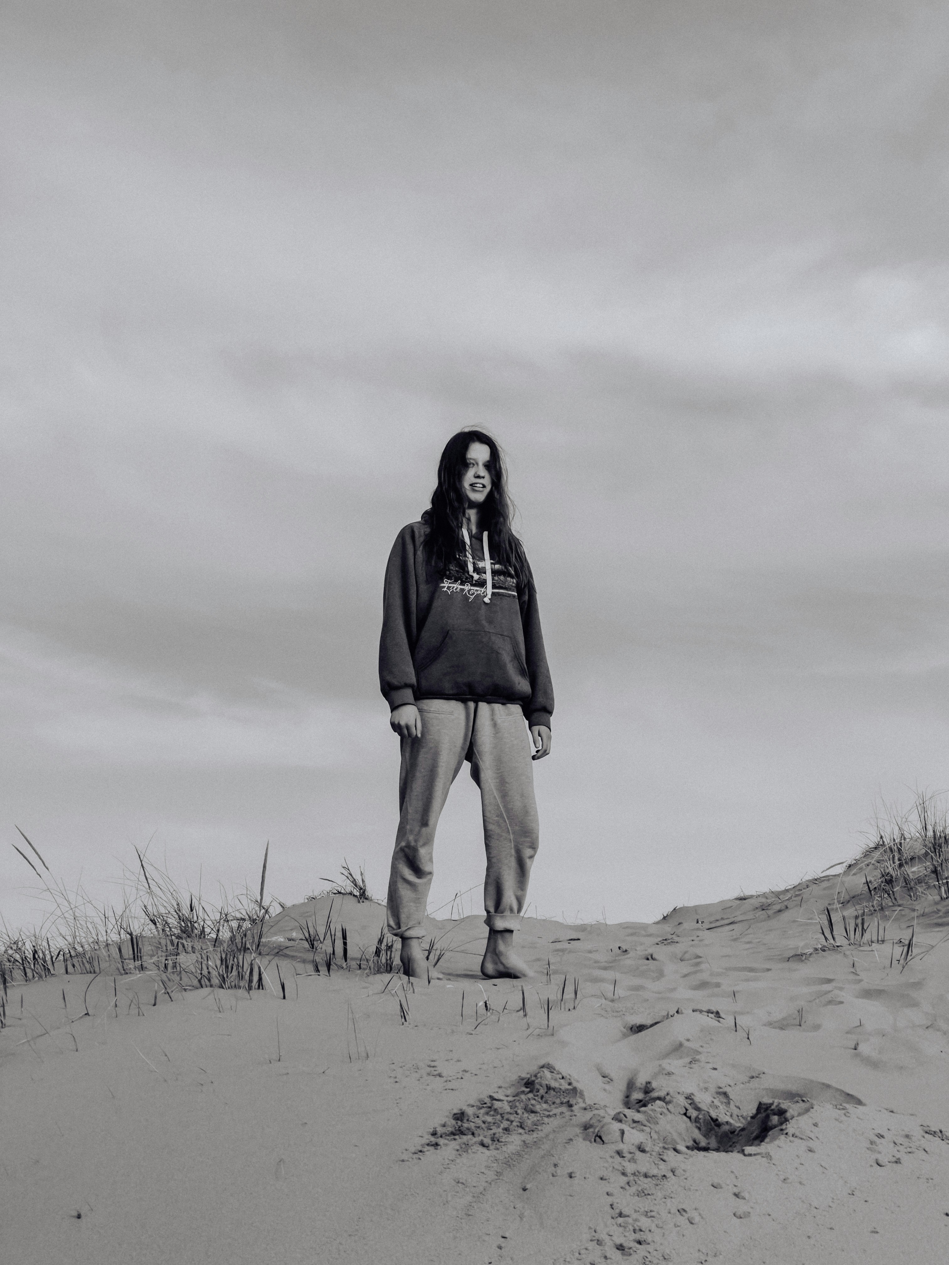 Lone Figure on a Dune: A Quiet Portrait Beneath a Gloomy Sky