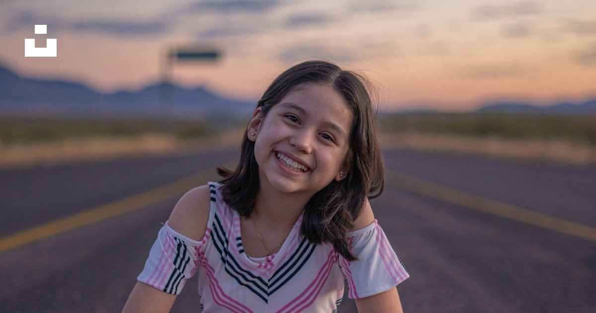 白と紫の縞模様のシャツを着た女性が昼間、道路に座っているの写真 Unsplashの無料道写真
