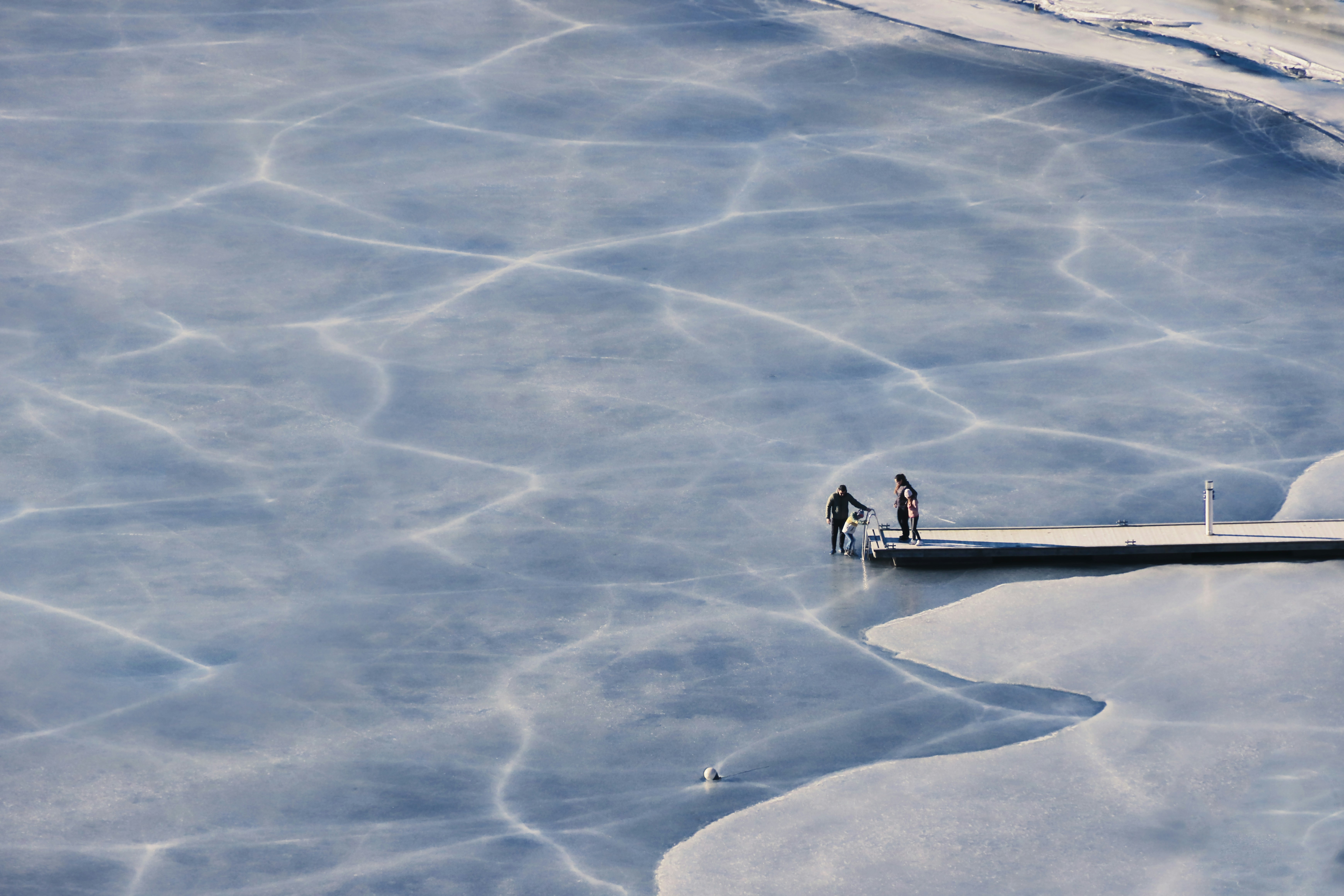 Distant Docks on a Frosted Wake: Two Figures at the Edge of Ice