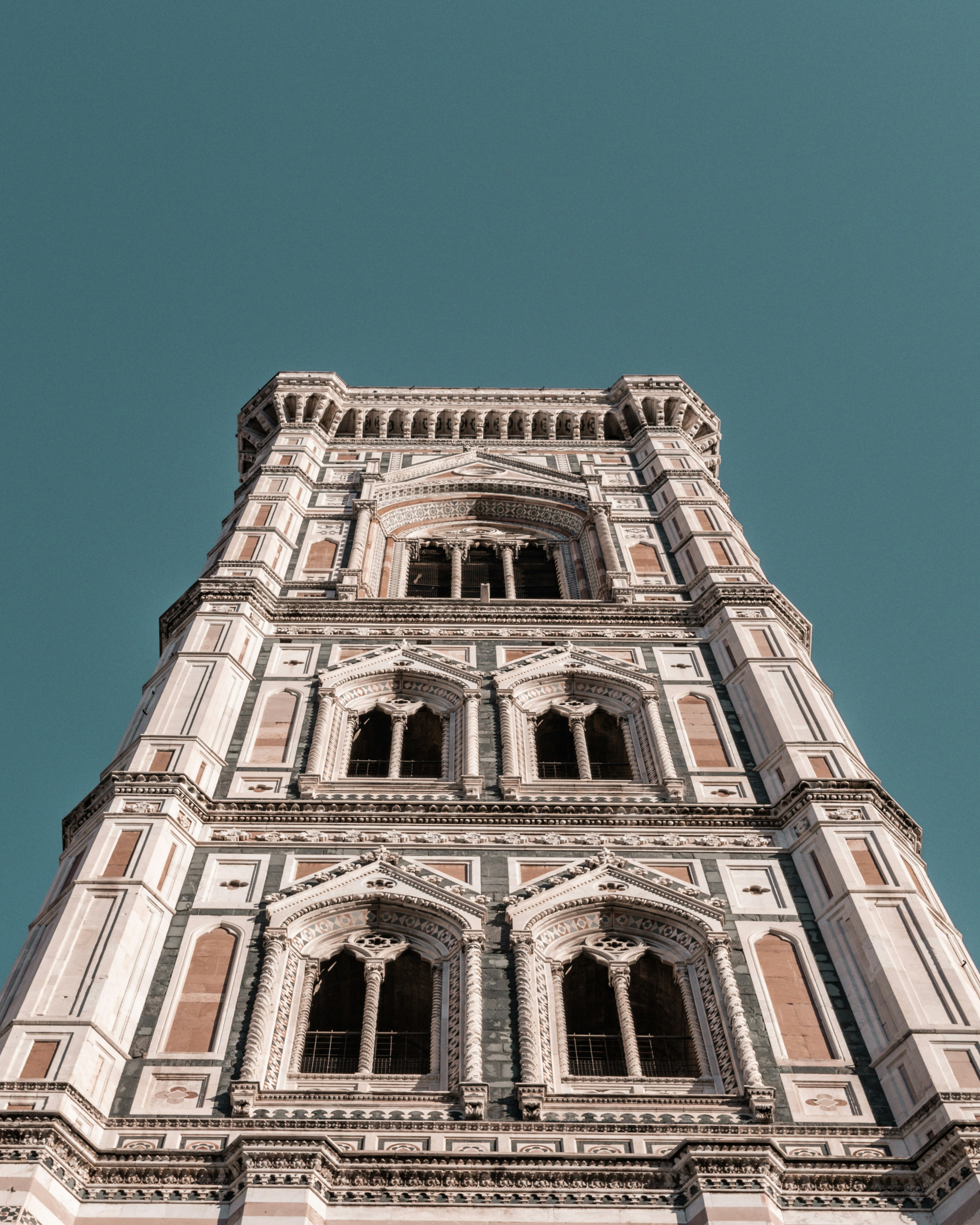 Imposing bell tower rises against a clear sky, showcasing intricate stonework and architectural details that reflect Renaissance artistry.