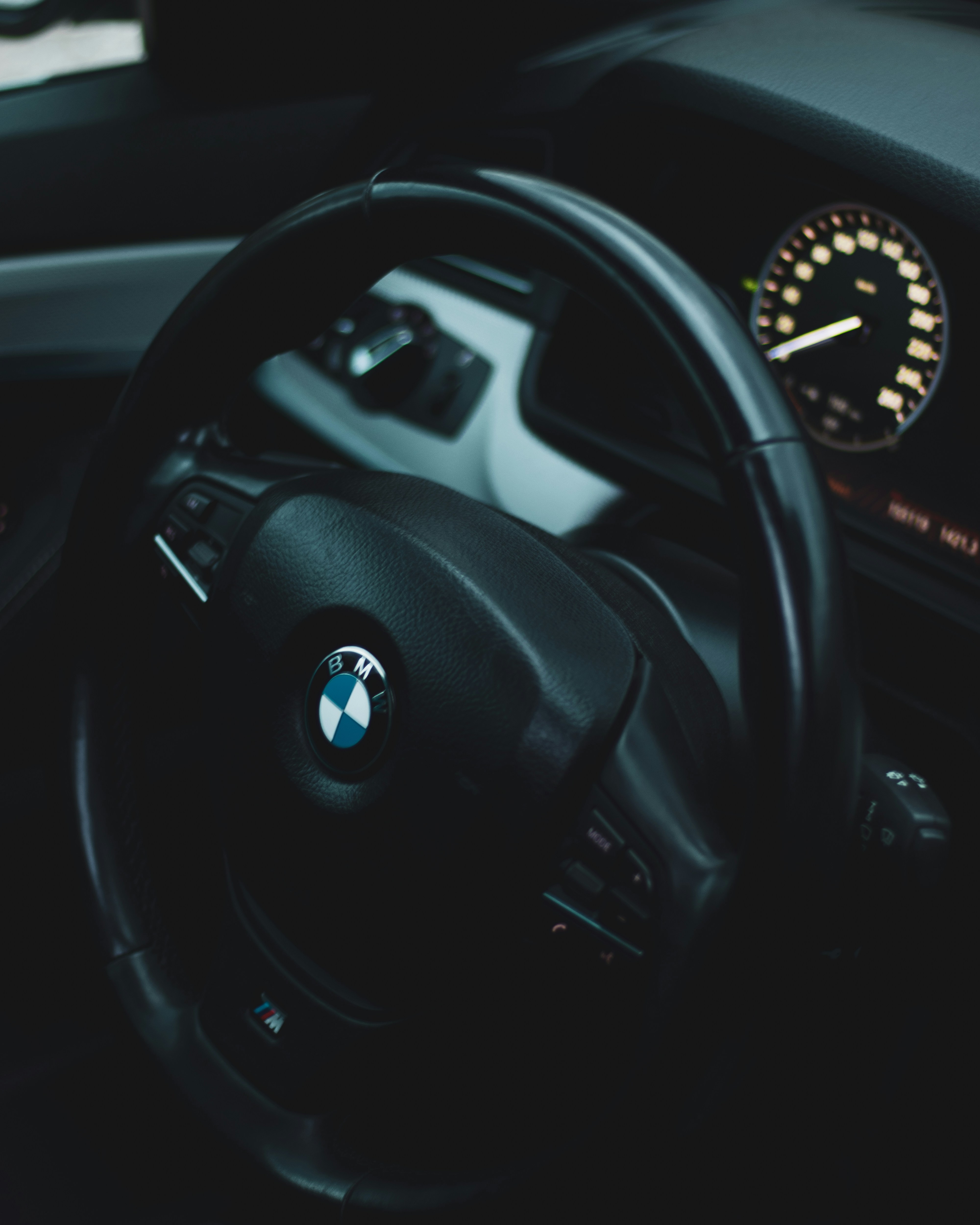 Midnight Cockpit: A Close-Up of the BMW Steering Wheel in Dim Light