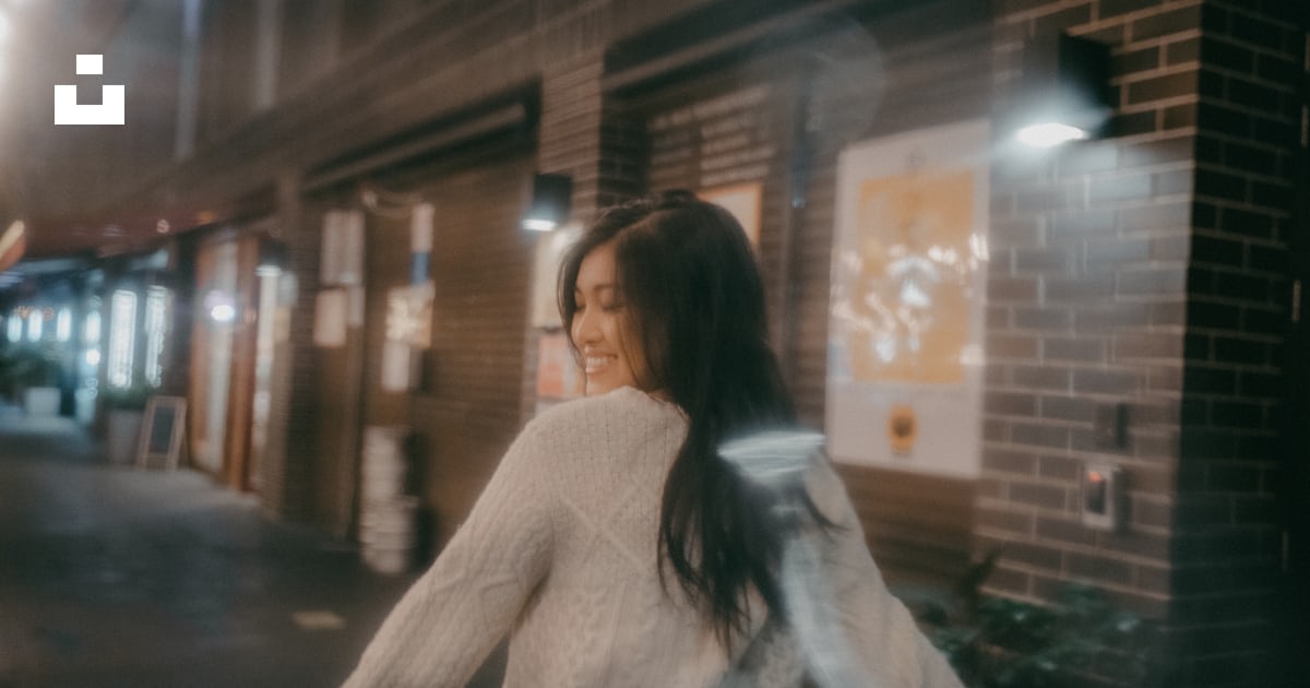 밤 시간 동안 보도에 앉아 흰 스웨터를 입은 여자 사진 Unsplash의 무료 도시 이미지