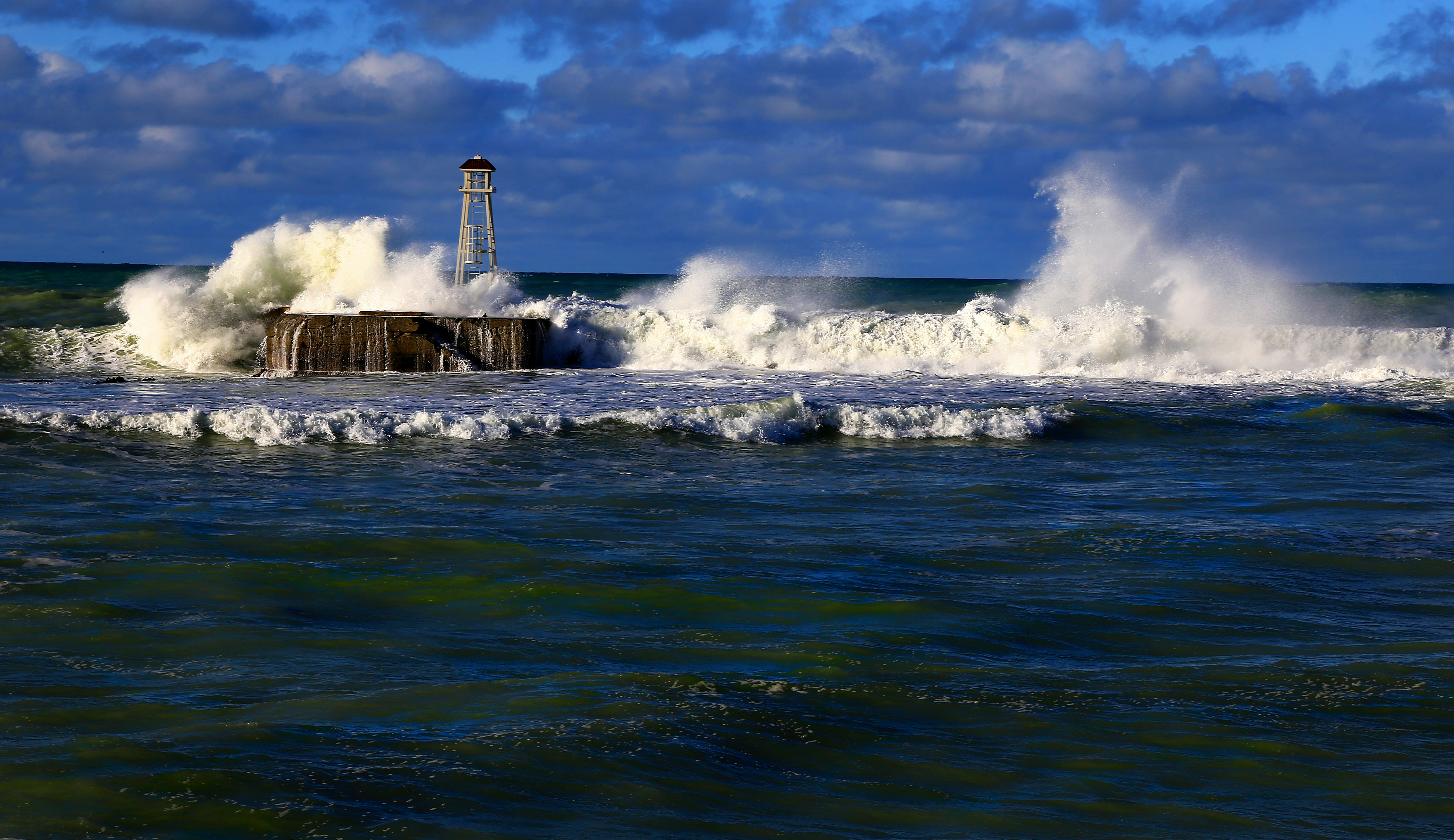 Wild Foaming waves crash over breakwater after storm.