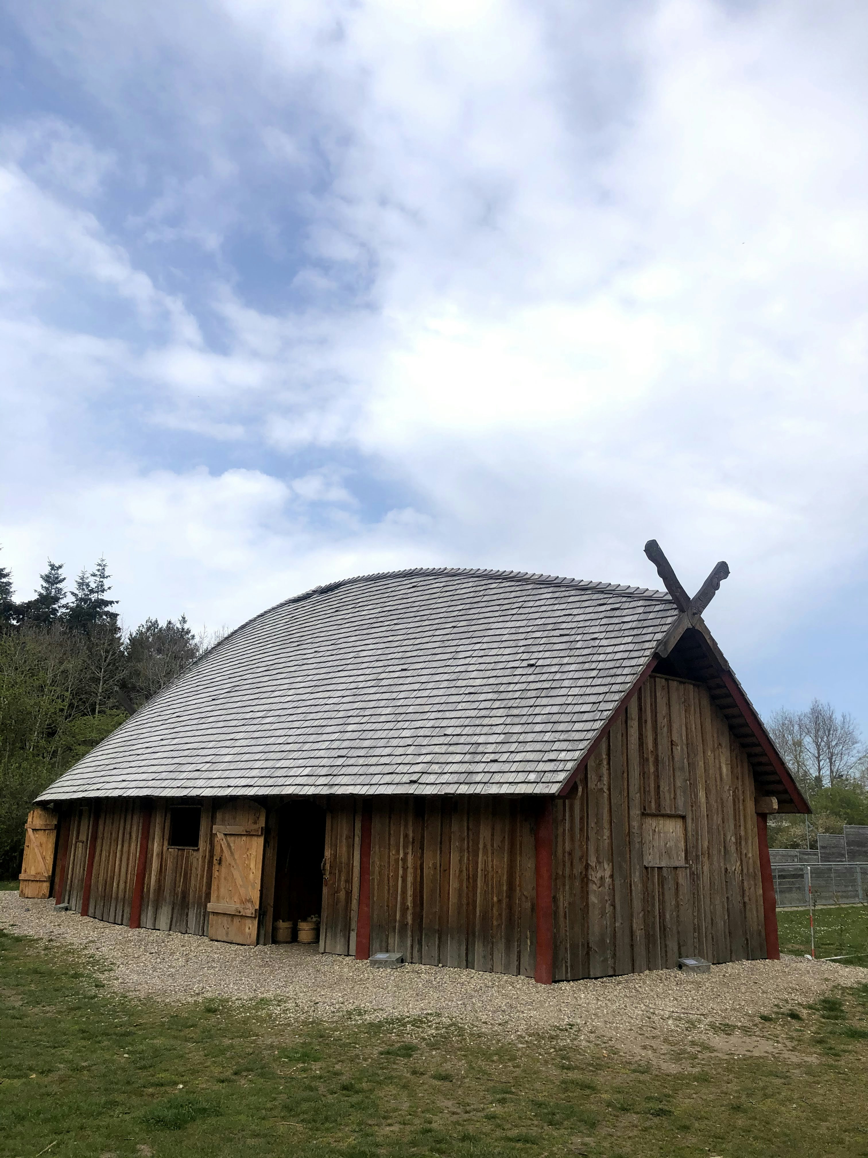 brown wooden barn on green grass field under white cloudy sky during daytime