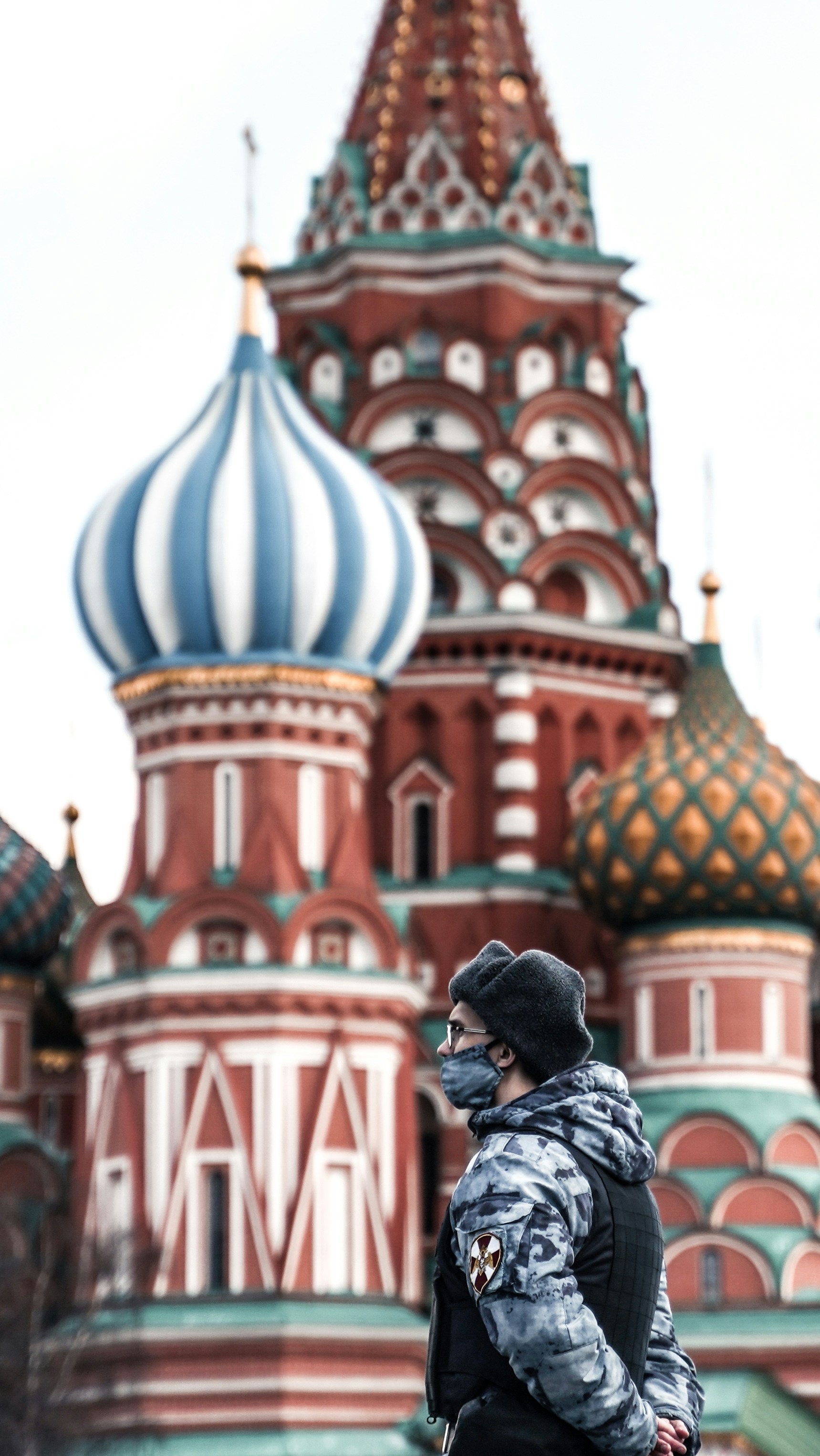A figure in military attire stands in front of St. Basil's Cathedral, showcasing a blend of modernity and historical architecture.