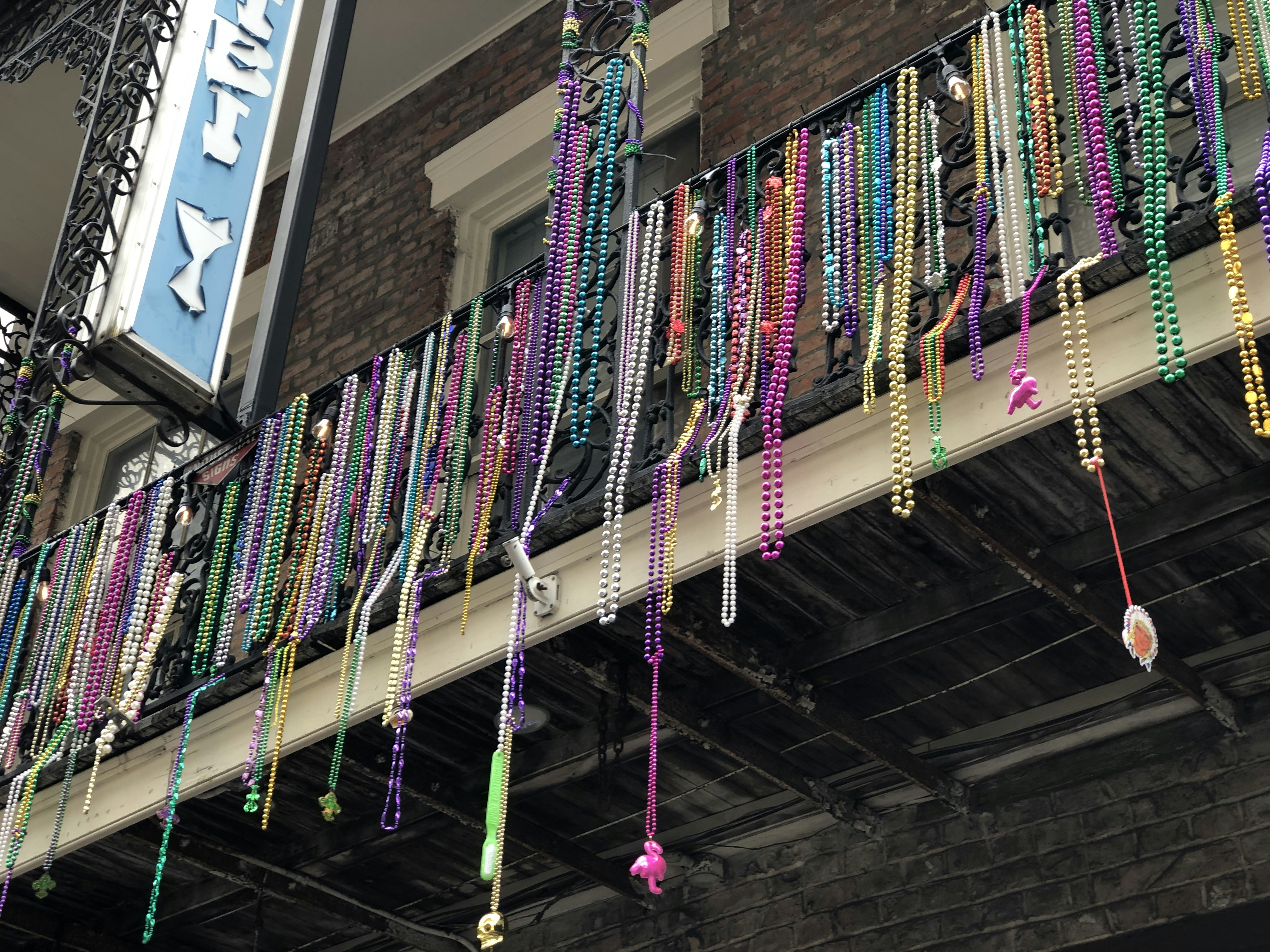 Colorful Mardi Gras Strings Over a Brick Balcony