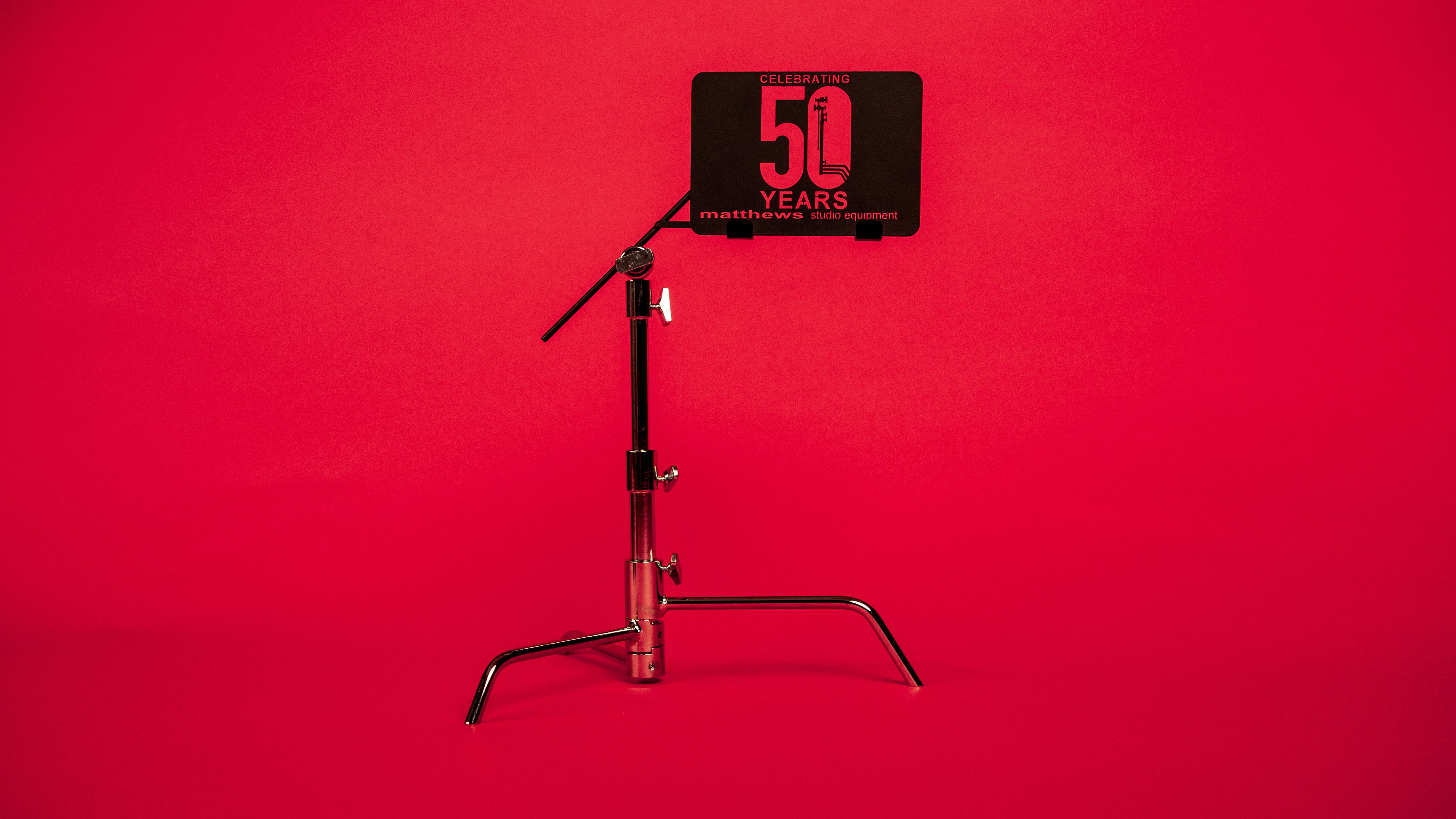 A Studio Stand Stands Bold Against Crimson Backdrop