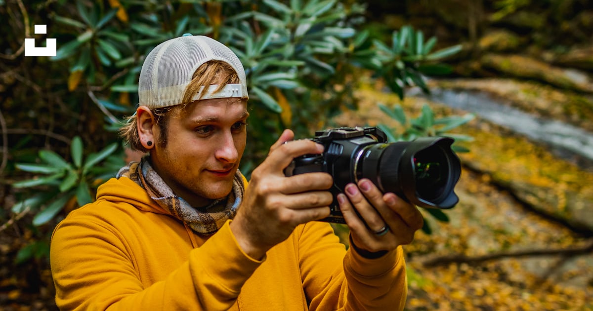 Hombre Con Chaqueta Amarilla Sosteniendo Una Cámara Dslr Negra Foto