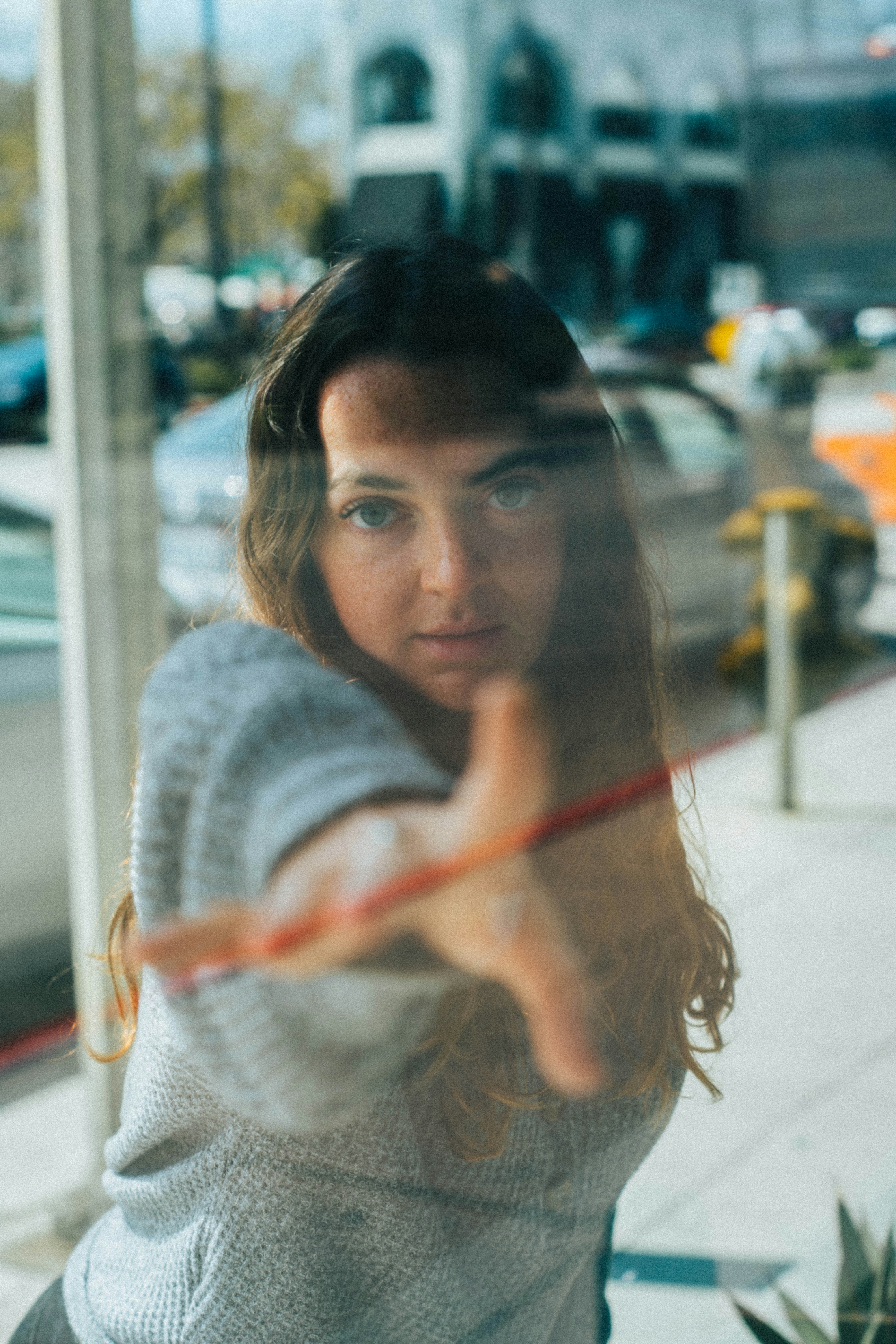 Gaze Through a City Window: A Portrait Behind Reflective Glass