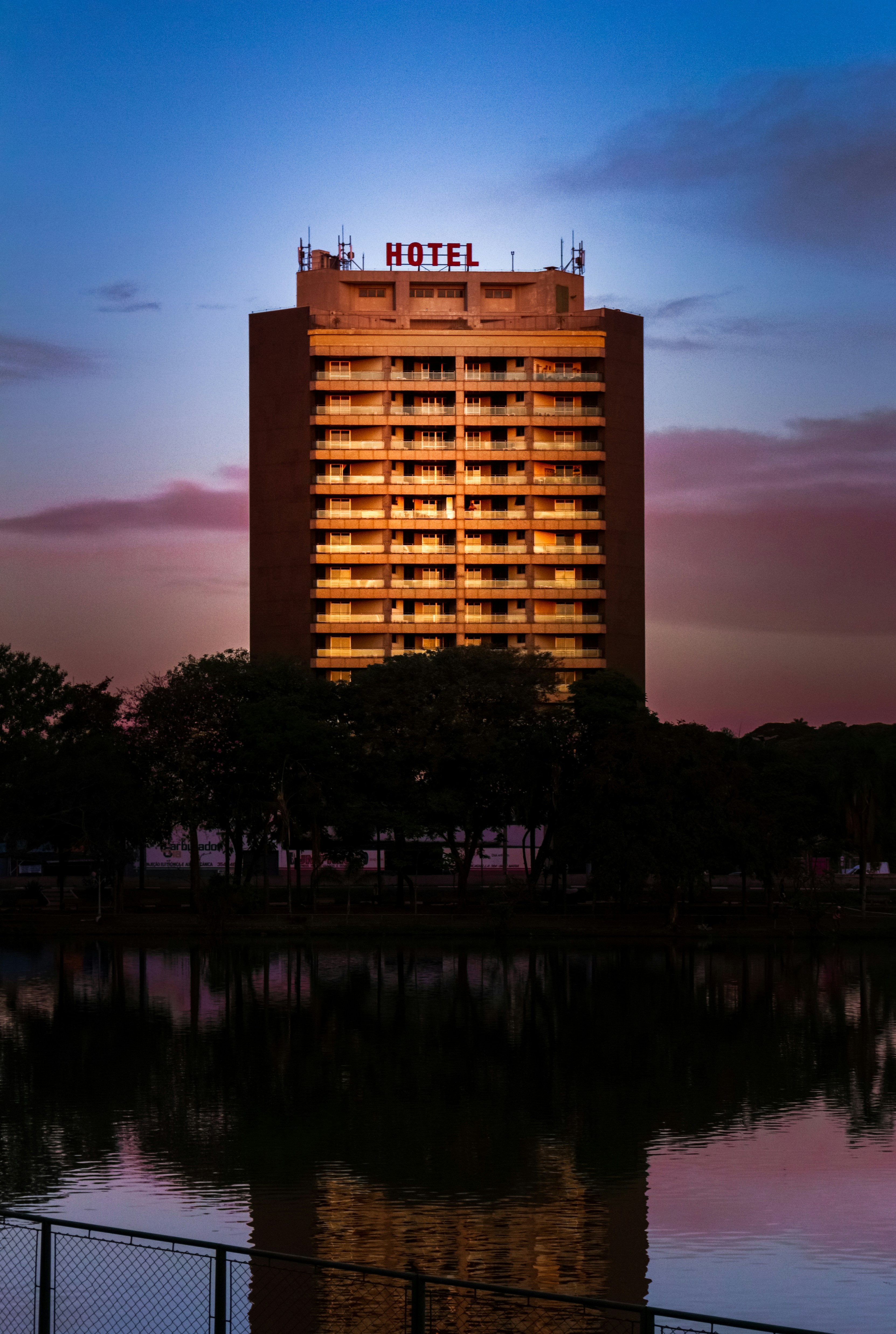 Dusk at the Amber Hotel: Golden Windows and Water Reflections