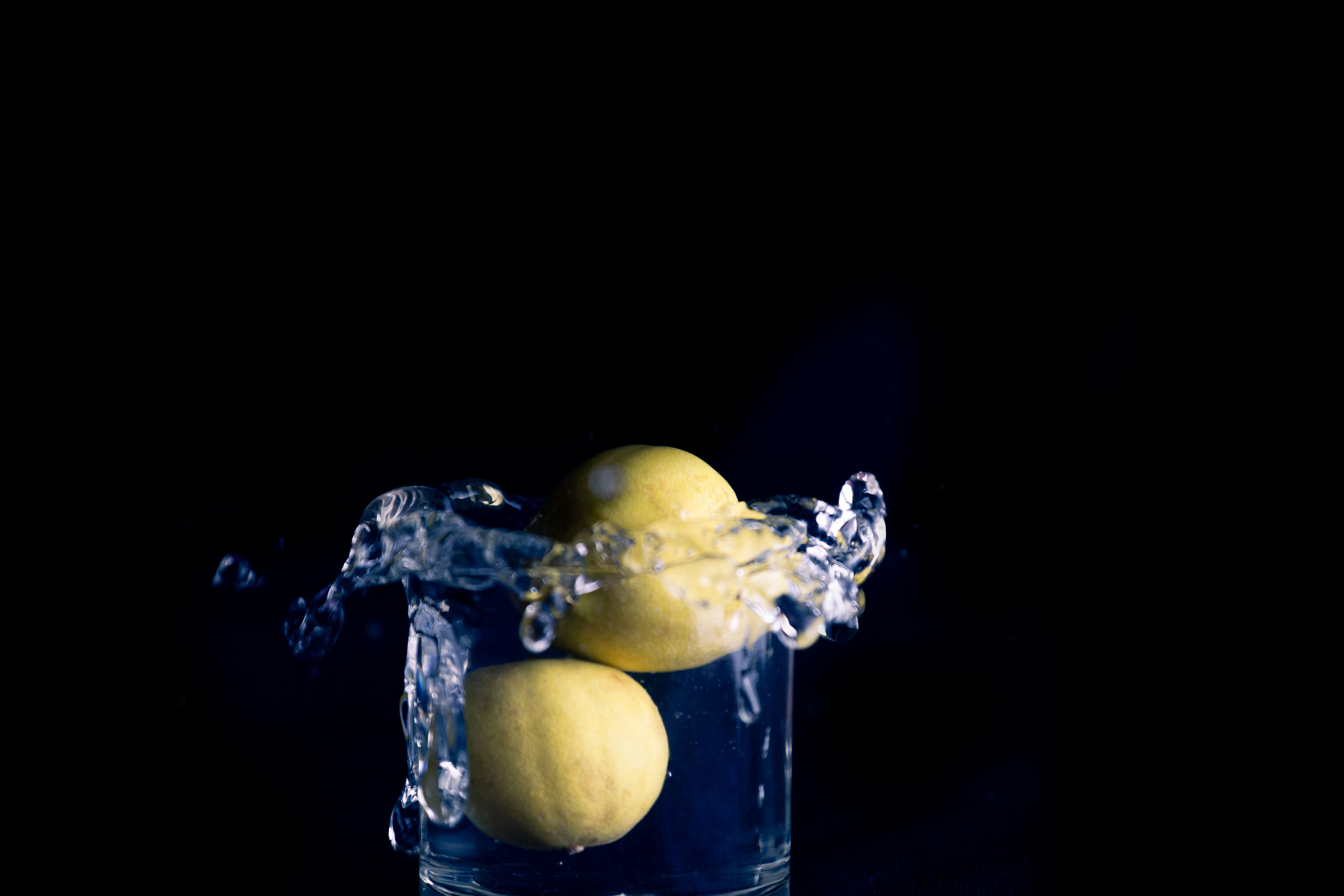 Citrus Splash: Two Lemons Crowned by a Cascade in a Glass