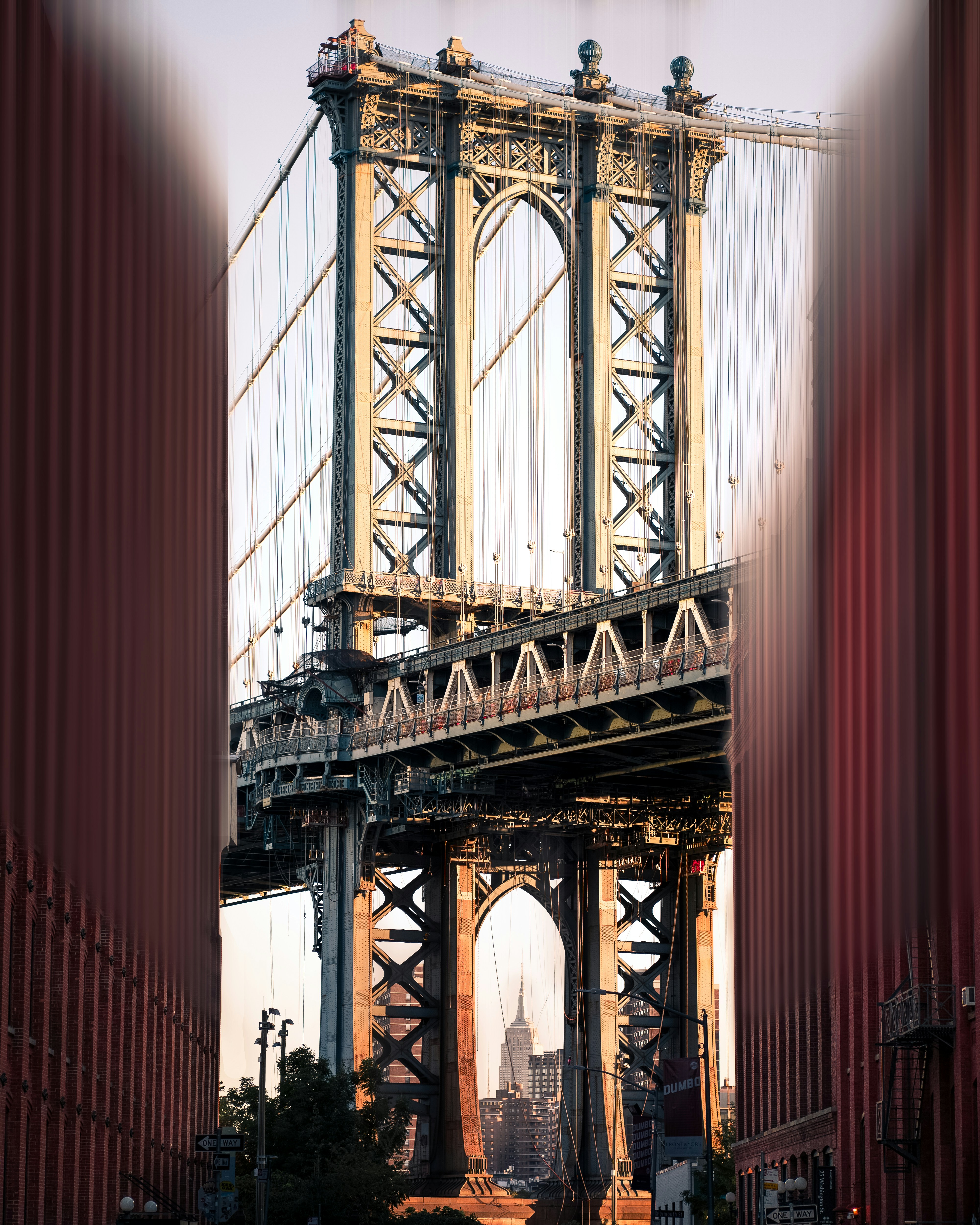 Empire State Framed by Iron Lace: A Cityscape Through the Manhattan Bridge