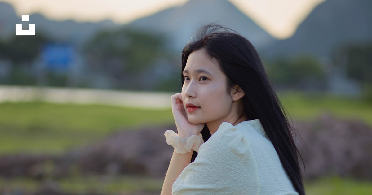 낮 동안 푸른 잔디밭에 앉아 있는 흰 셔츠와 베이지색 바지를 입은 여자 사진 Unsplash의 무료 아름다운 소녀들 이미지