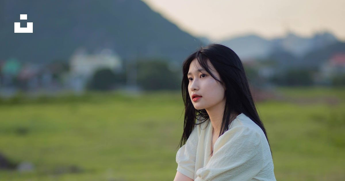 낮 동안 푸른 잔디밭에 앉아 하얀 드레스를 입은 여자 사진 Unsplash의 무료 밝은 배경 이미지