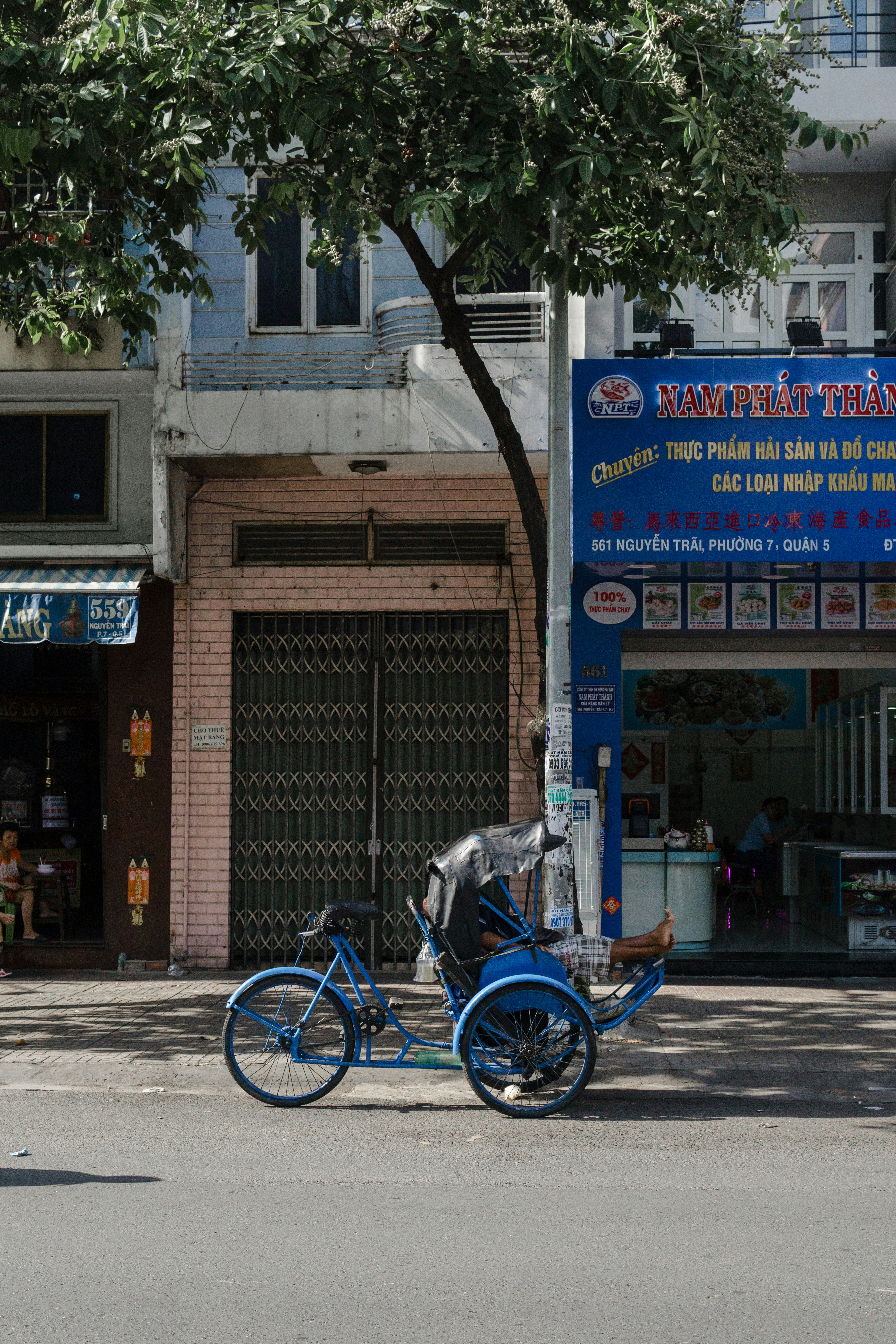 Blue Pedicab in Front of a Market Storefront