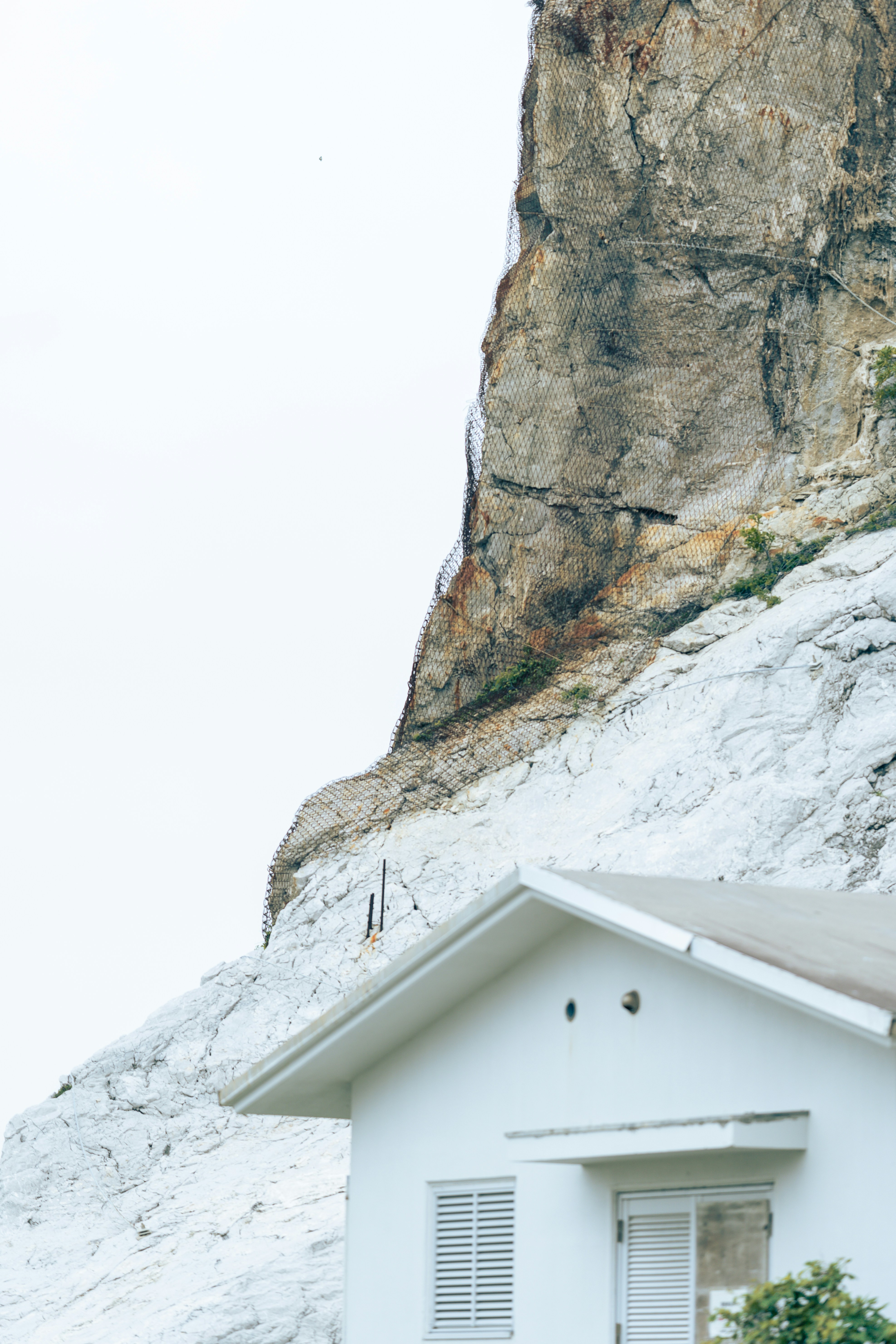 Cliffside White Cottage Braced by a Weathered Granite Slope