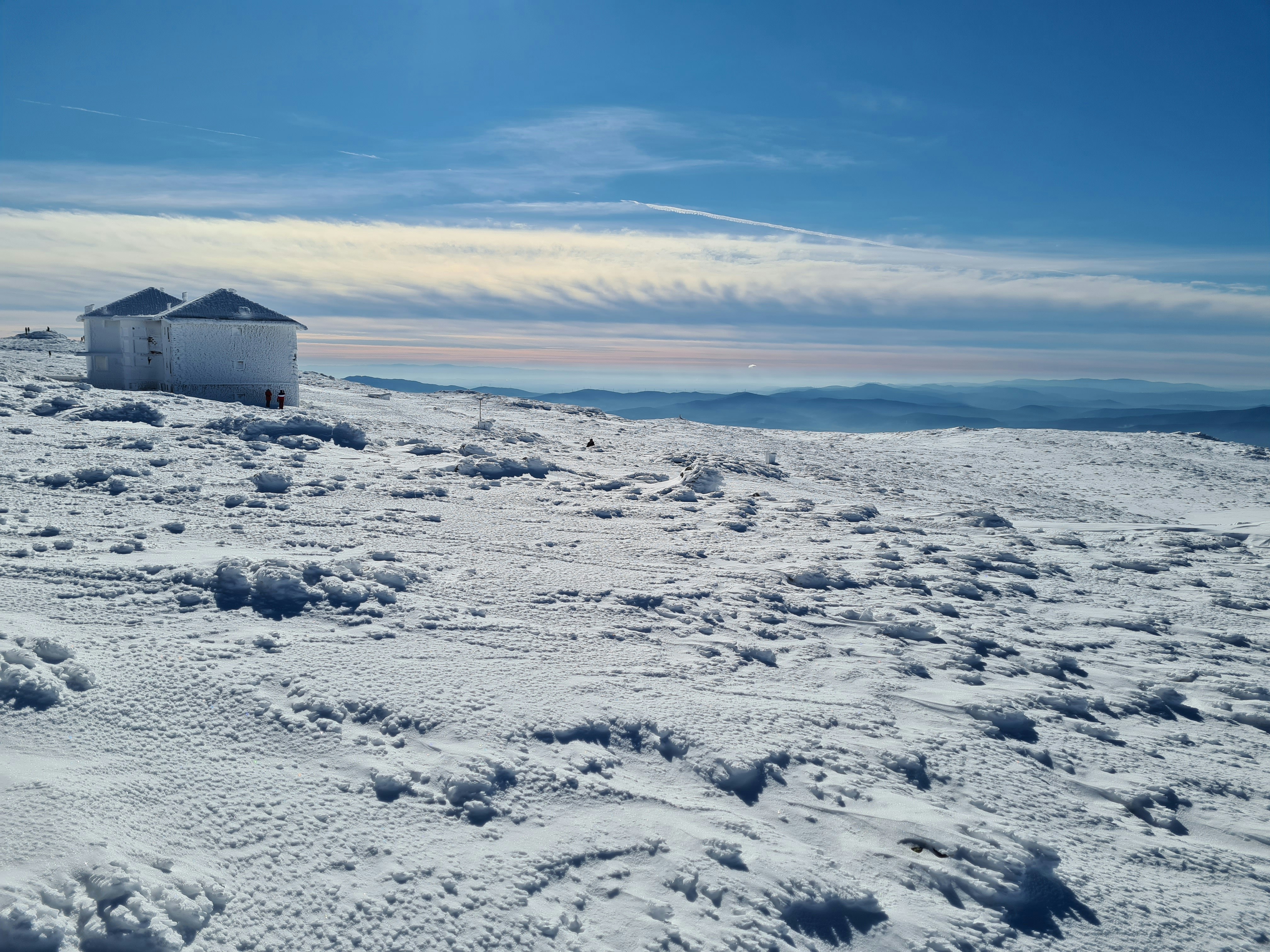Snowbound Huts on a Wind-Swept Plateau Under a Striped Sky