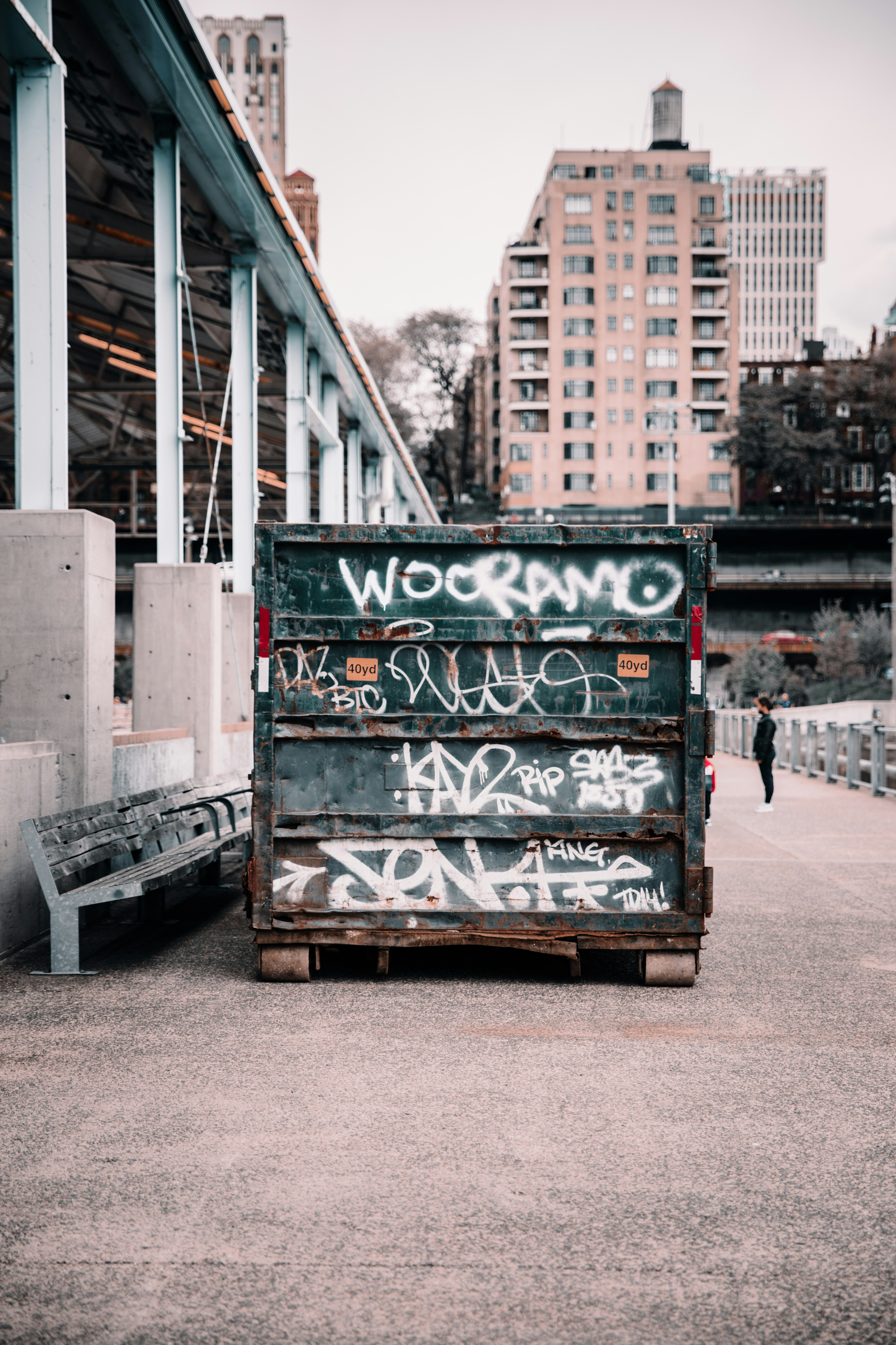 Graffiti Dumpster in a Riverside Cityscape