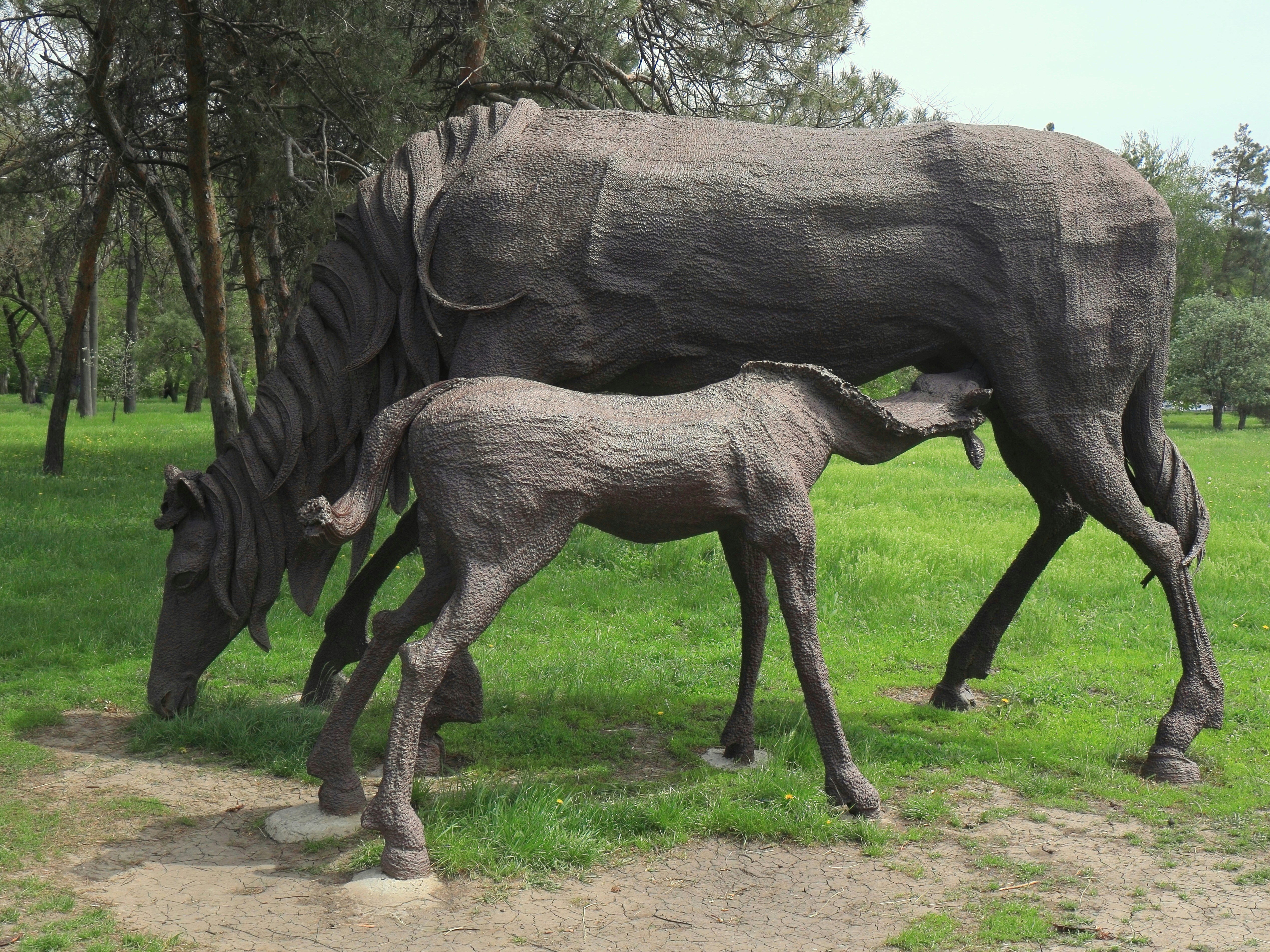 Nuzzling Giants: A Mare and Foal Share a Moment on Green Turf
