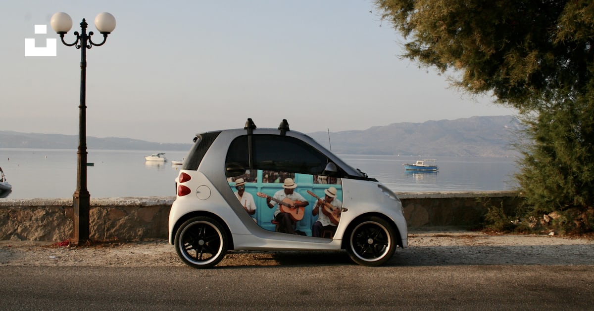 White And Black Volkswagen Beetle Parked On Gray Concrete Road During