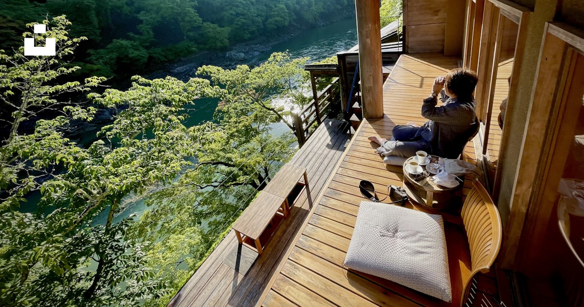 昼間、緑の木々のそばの茶色の木のベンチに座っている人々の写真 Unsplashの京都府 日本の無料画像
