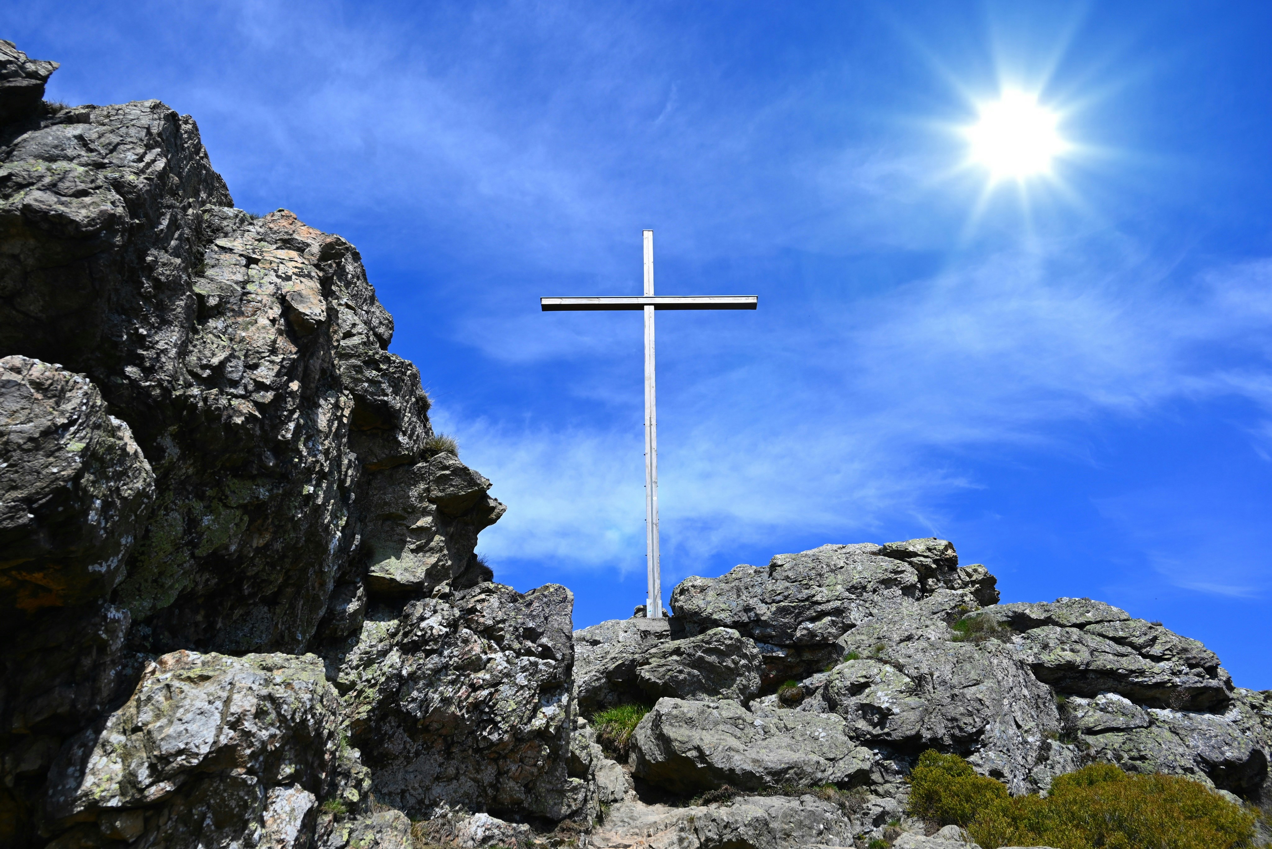 Cross on rocky mountain under blue sky during daytime photo – Free ...
